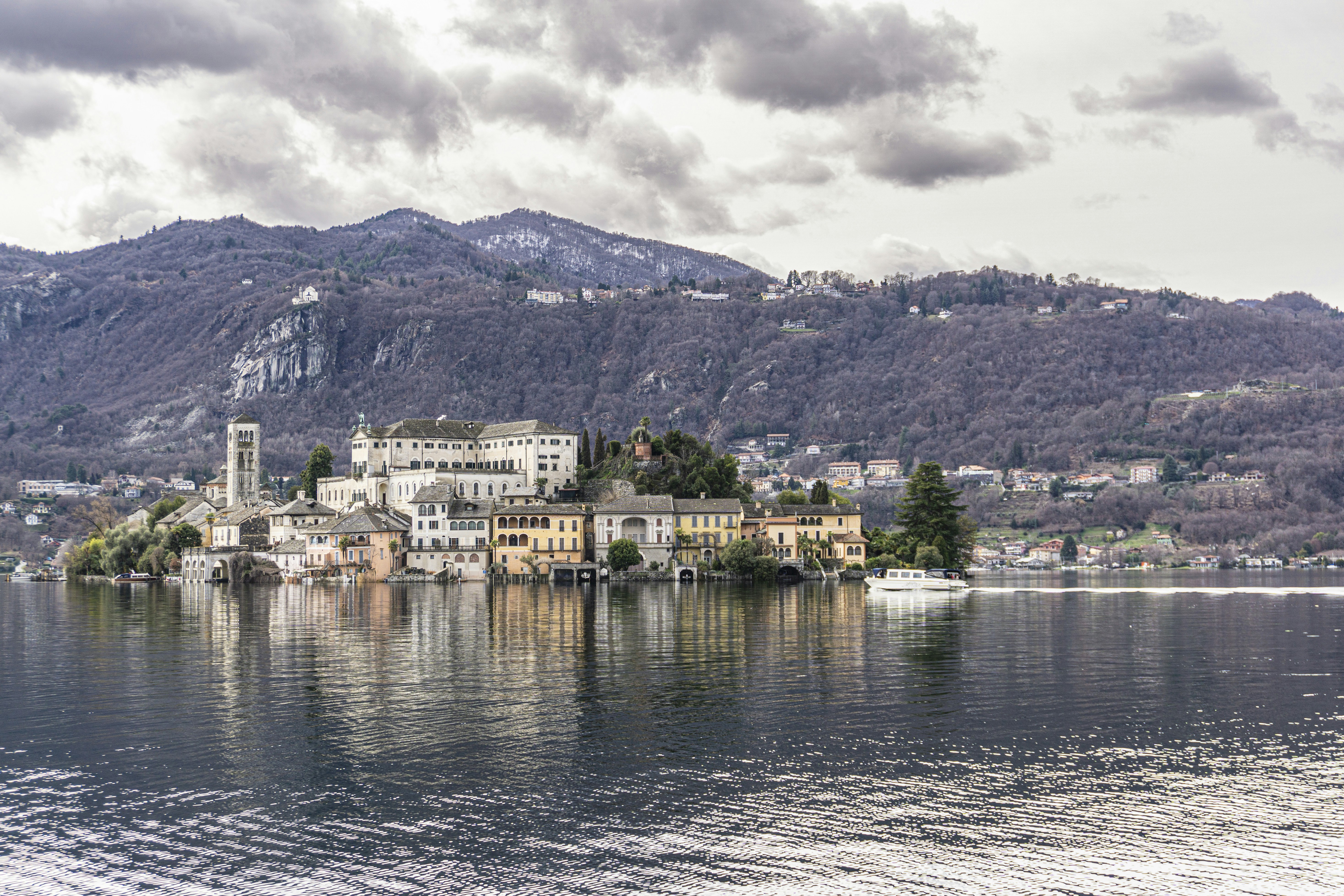 A small island in the middle of a lake photo – Free Lago d'orta Image ...