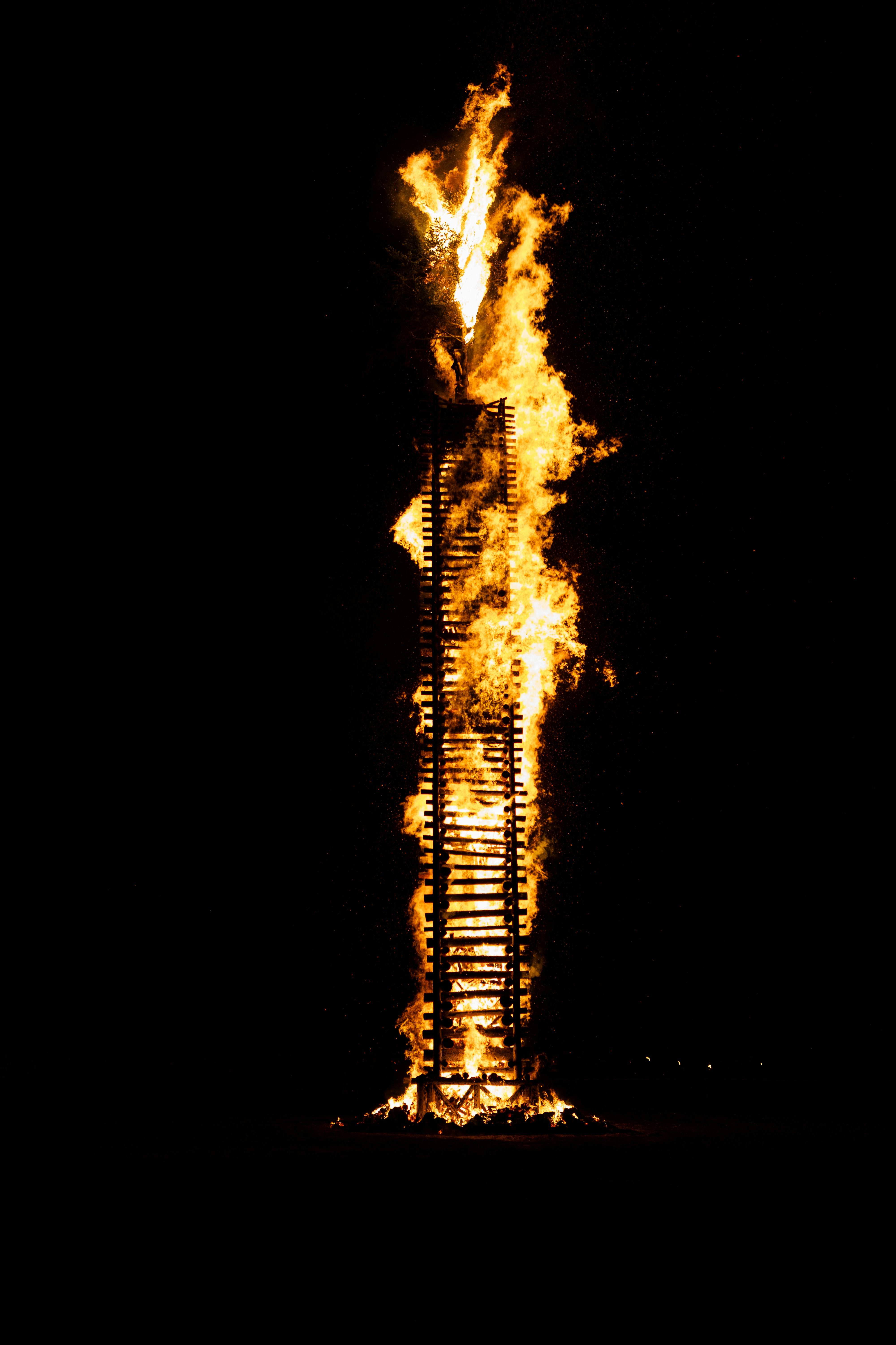 Inferno Tower: A Midnight Bonfire Engulfs a Tall Wooden Scaffold