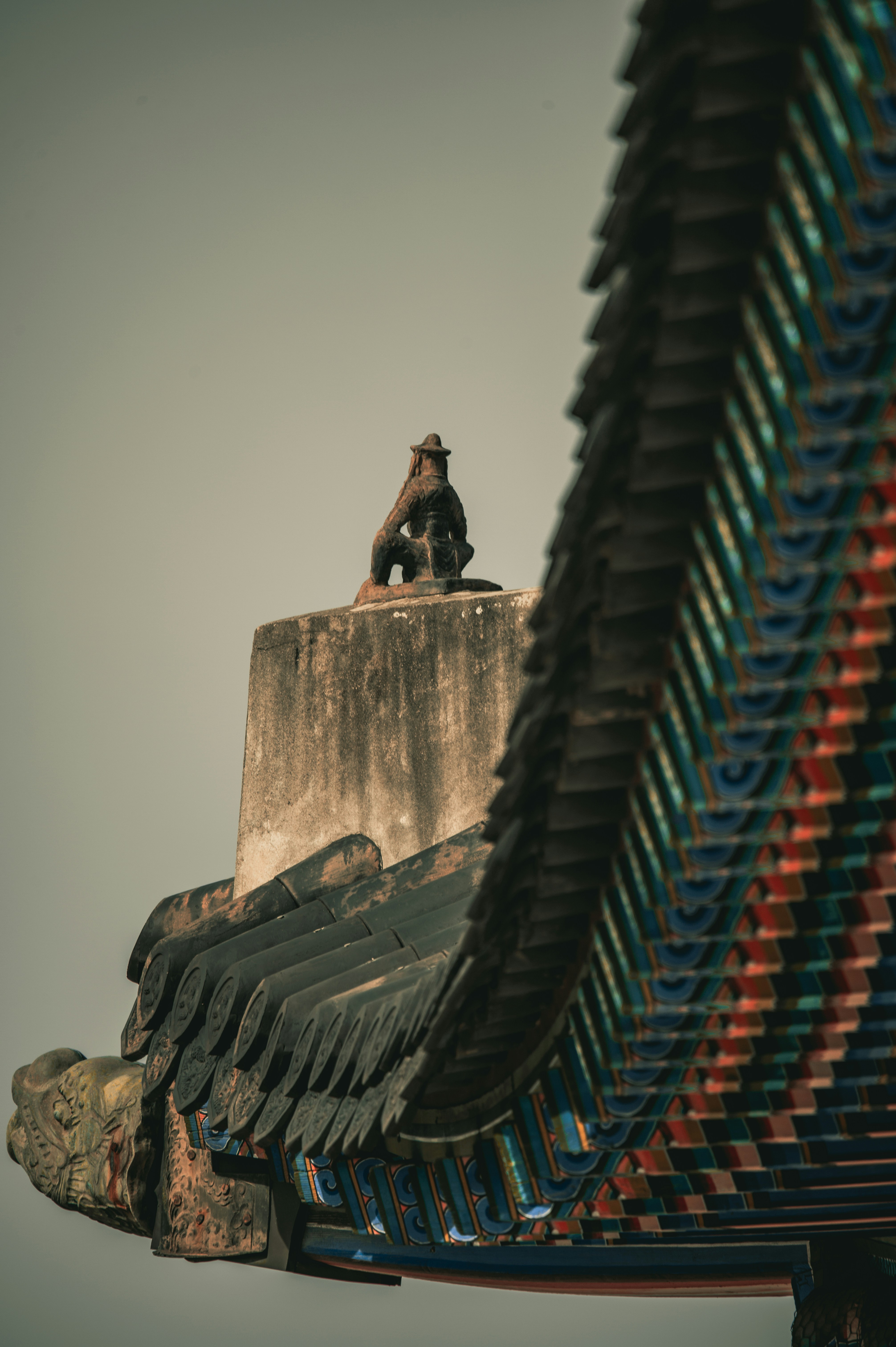 Stone Sentinel Guarding the Curve of a Chinese Tile Roof