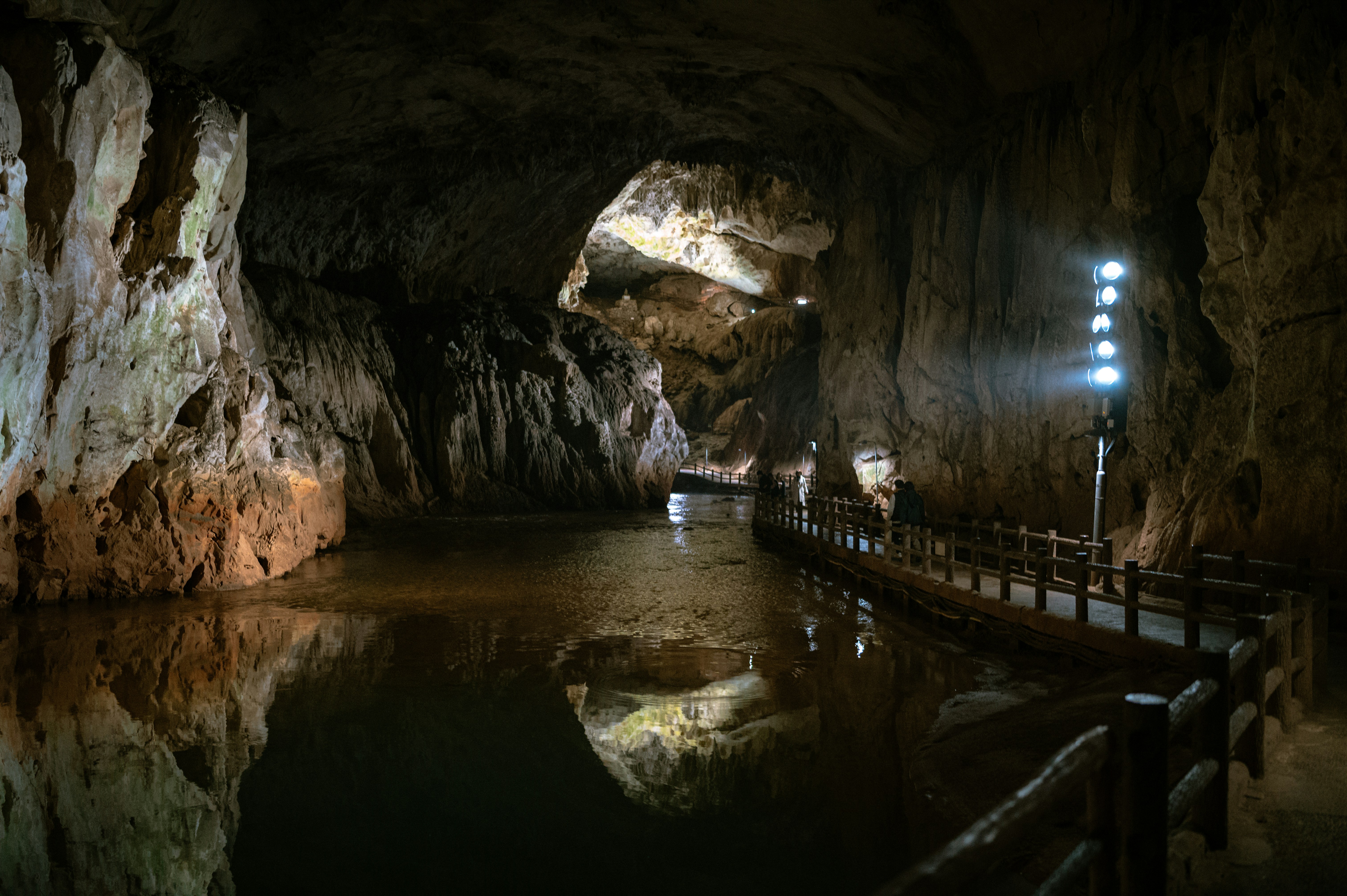 A large cave with a pool of water inside of it photo – Free Nature ...