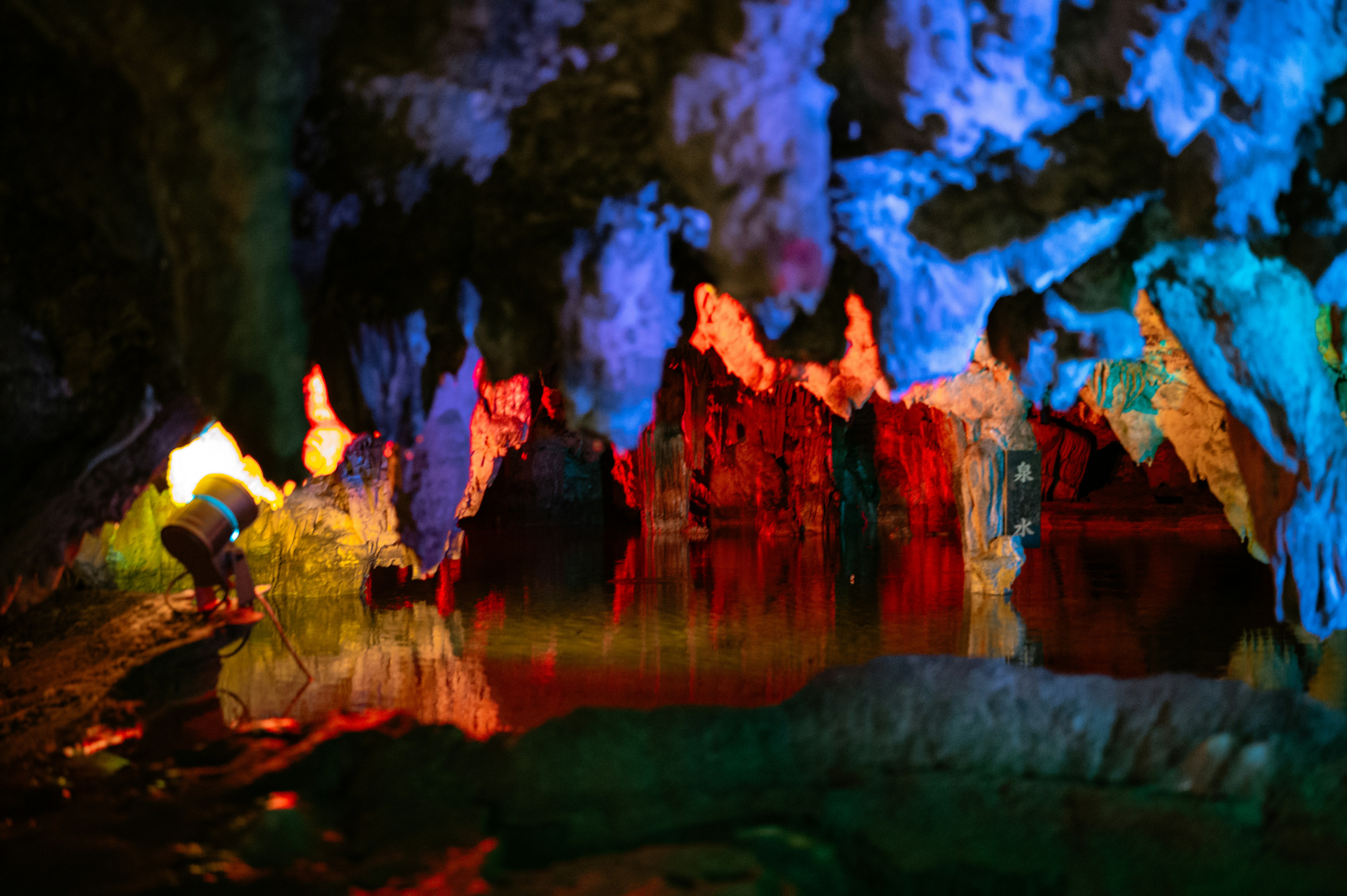 A group of people standing in a cave next to a body of water photo ...