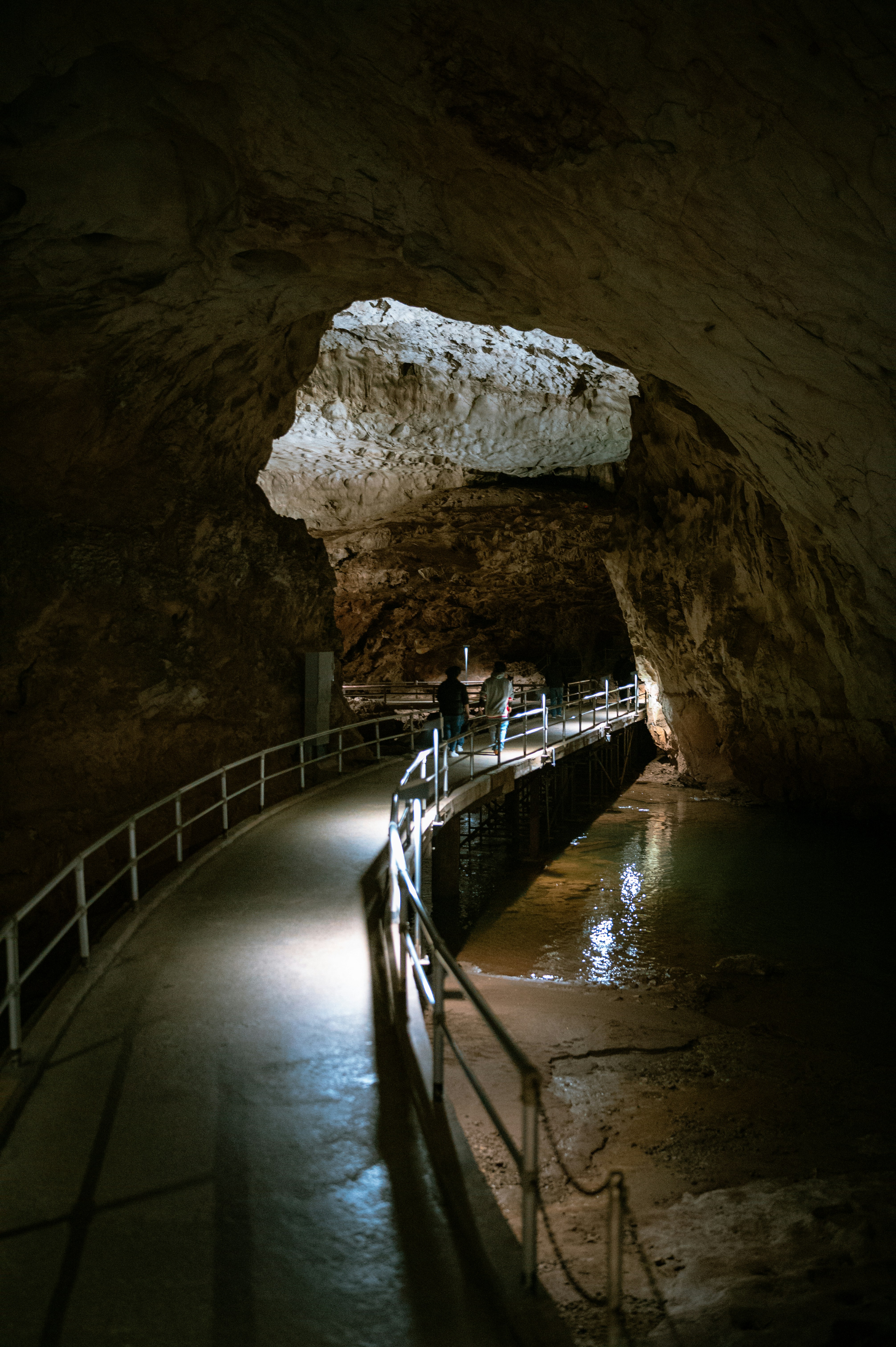 A walkway leading into a cave filled with water photo – Free Nature ...