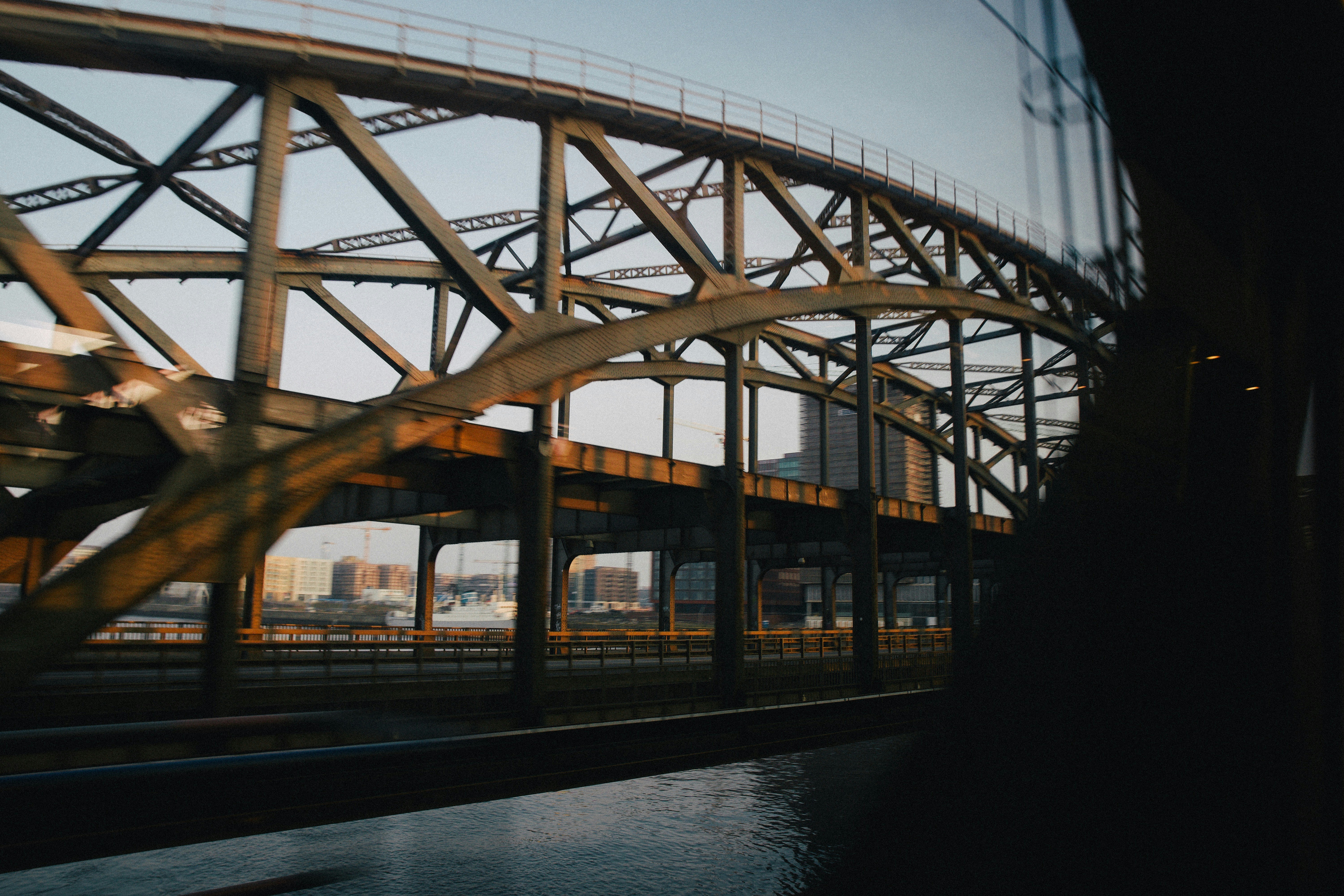 Rust and Rivets: A Bridge Framing a Quiet River with a Distant Skyline