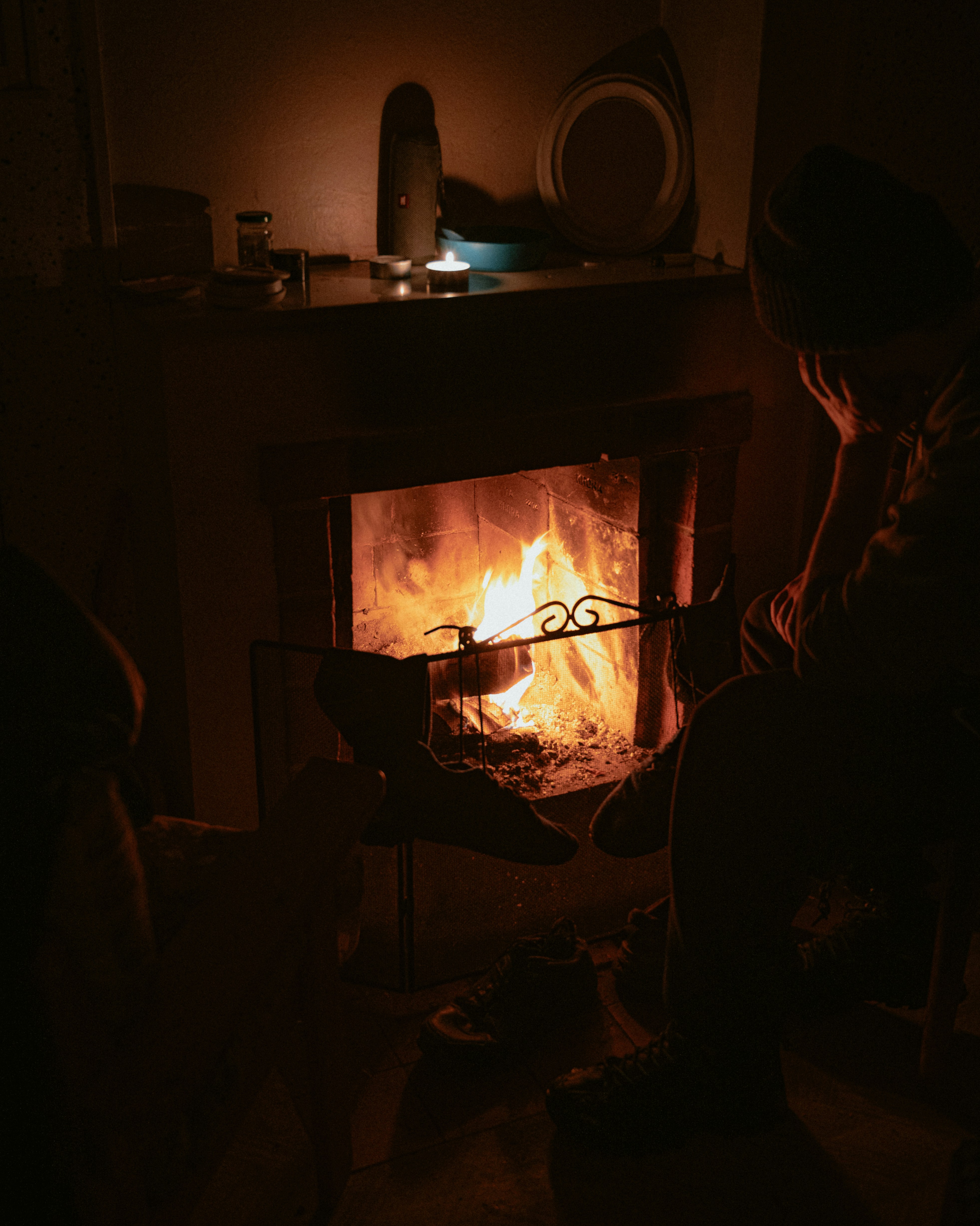 a person sitting in front of a fire in a fireplace