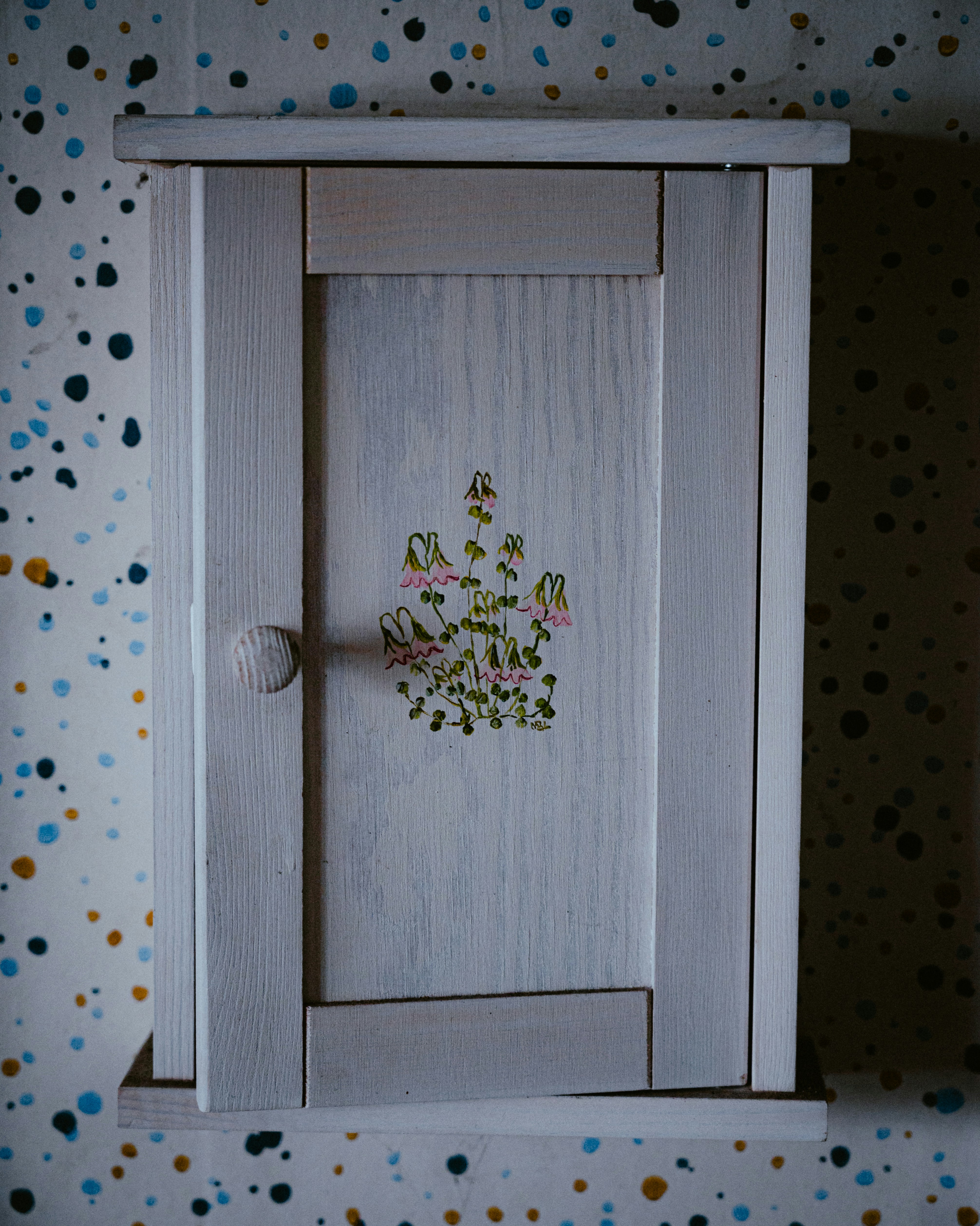 Tiny Cabinet, Big Detail: A Hand-Painted Bloom on White Wood