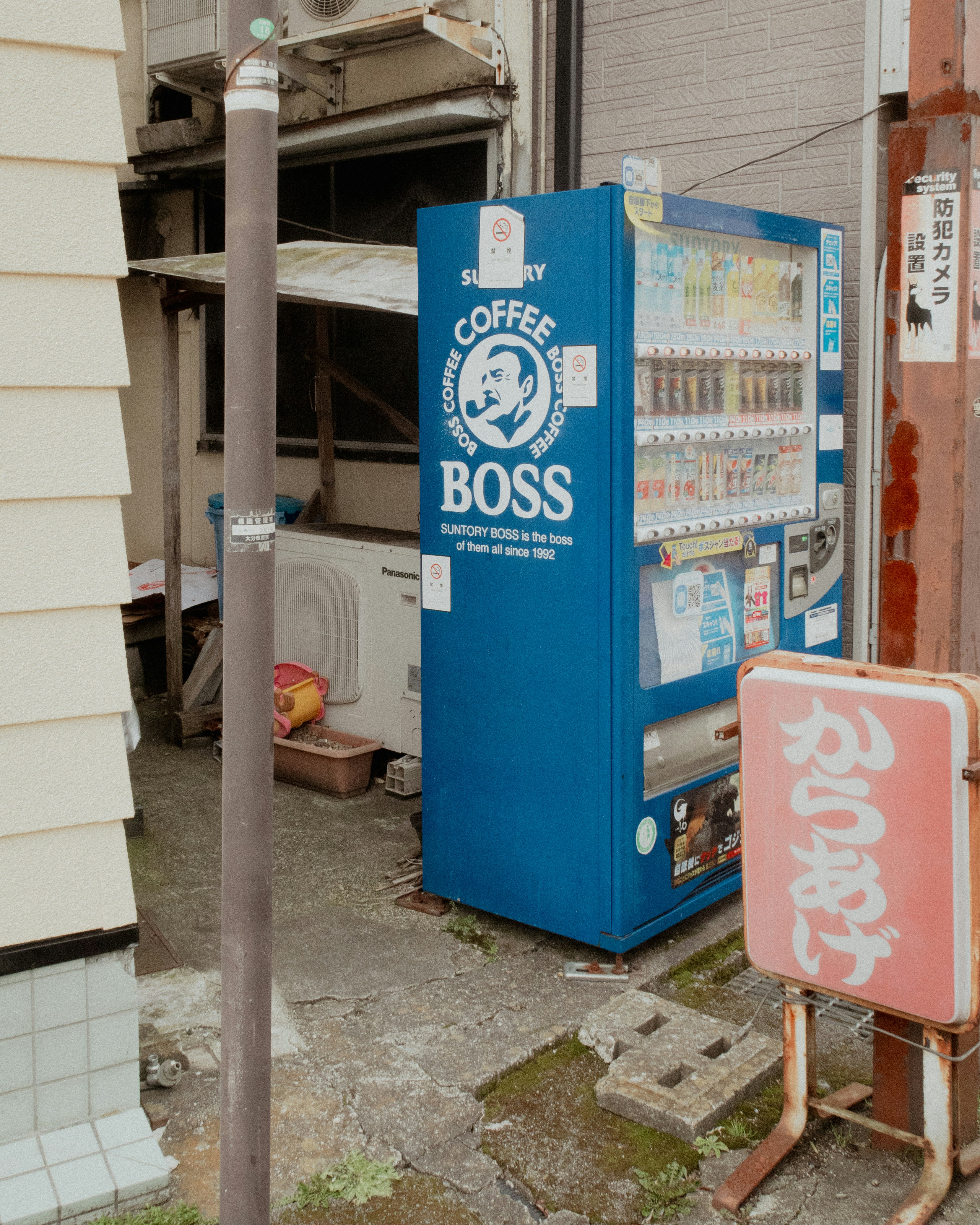 A blue vending machine sitting next to a building photo – Free Human ...