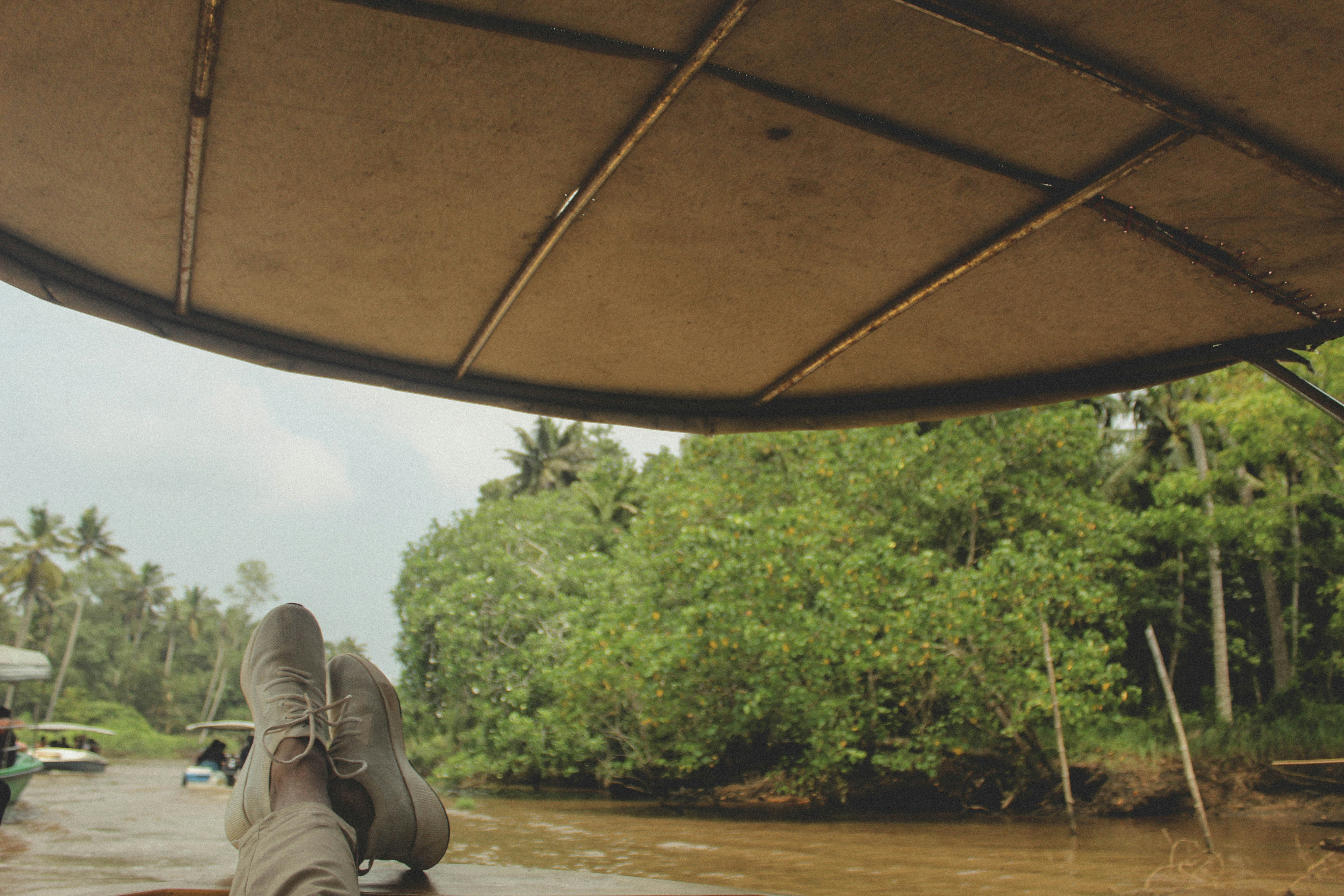 Boots at the Bow: A Sunlit River Backwater