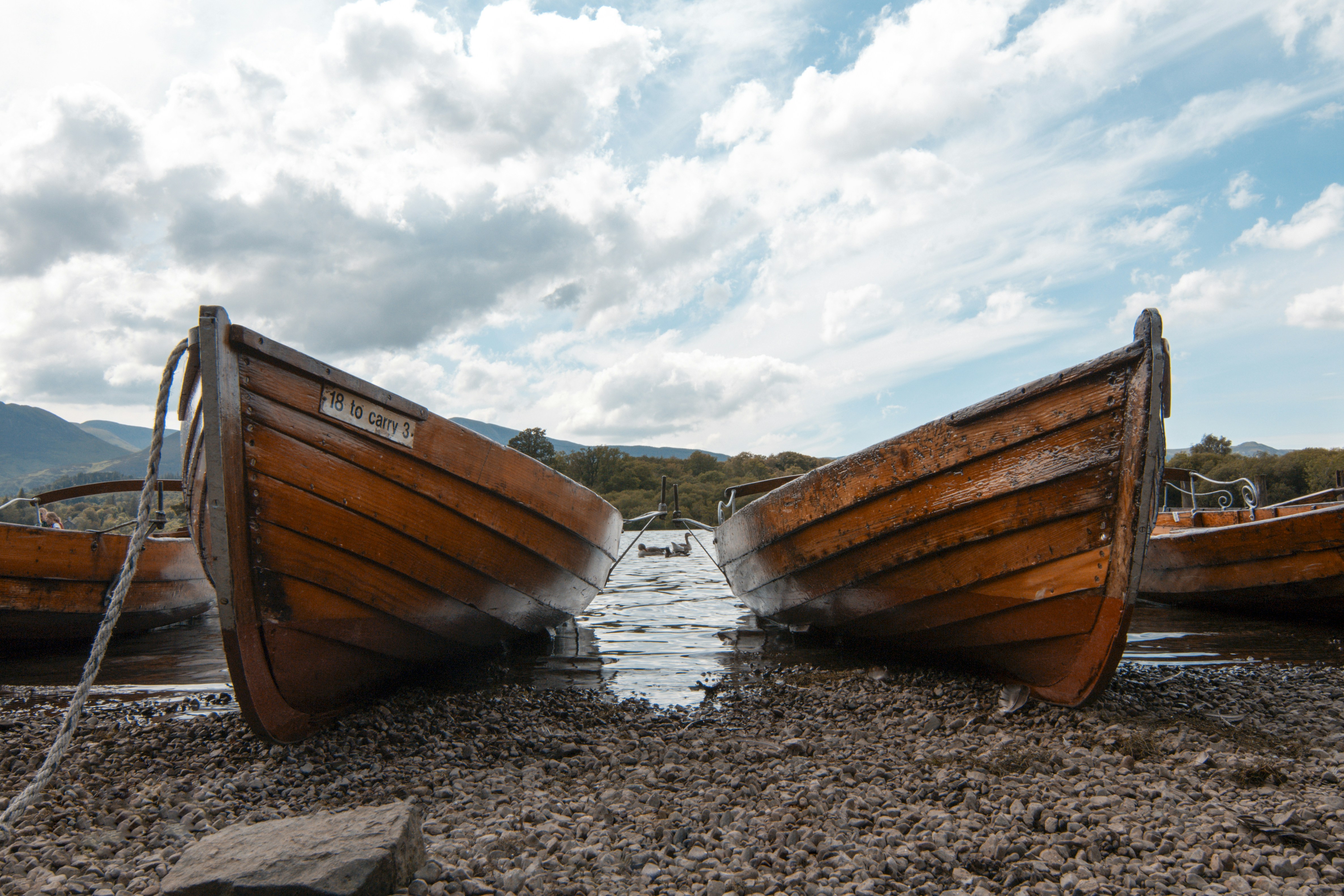 Between Two Boats: Cedar hulls Resting on a Pebbled Shore