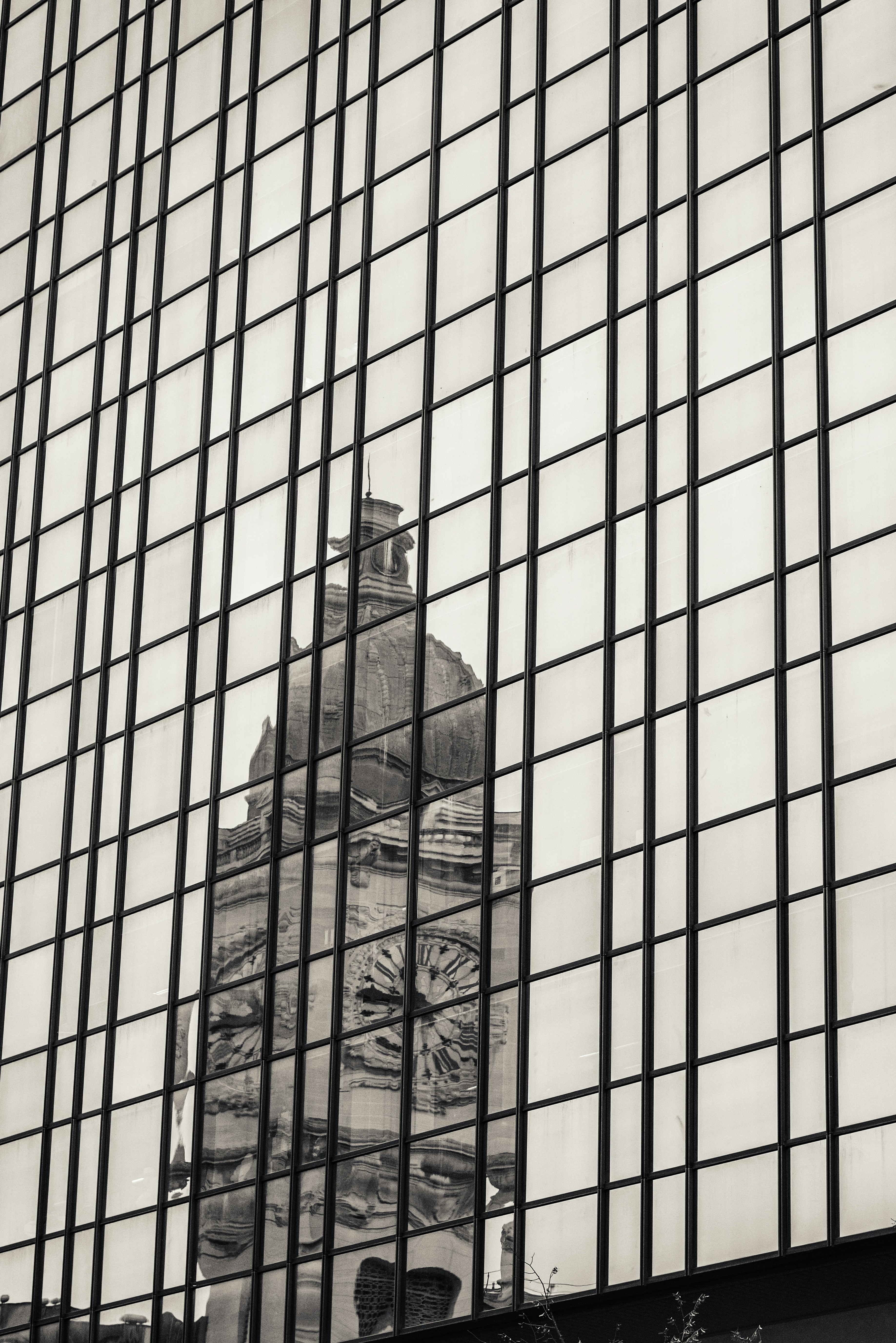 Gridlined Echo: Reflected Clock Tower in a Glass Facade