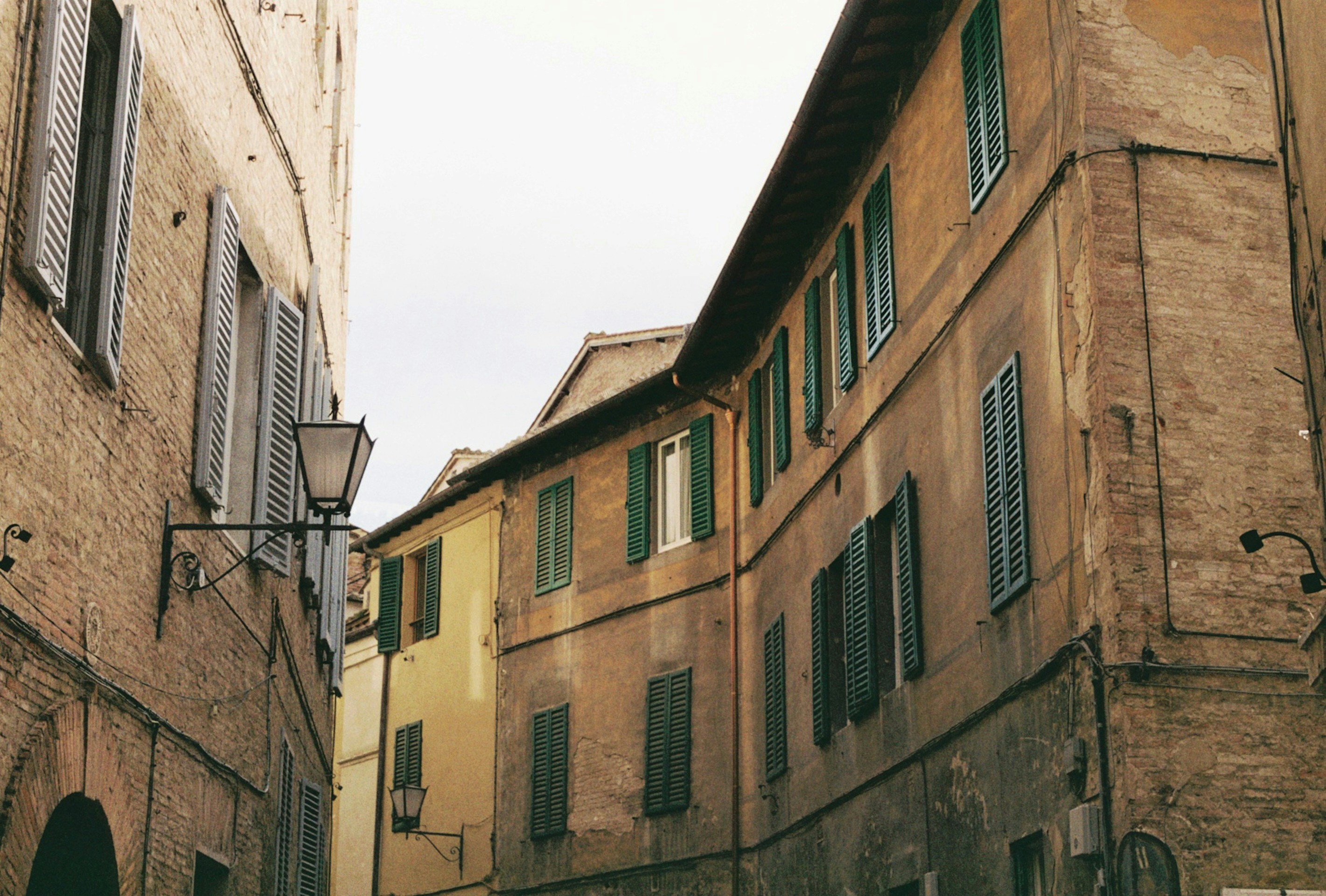 A narrow alleyway between two buildings with shuttered windows photo ...