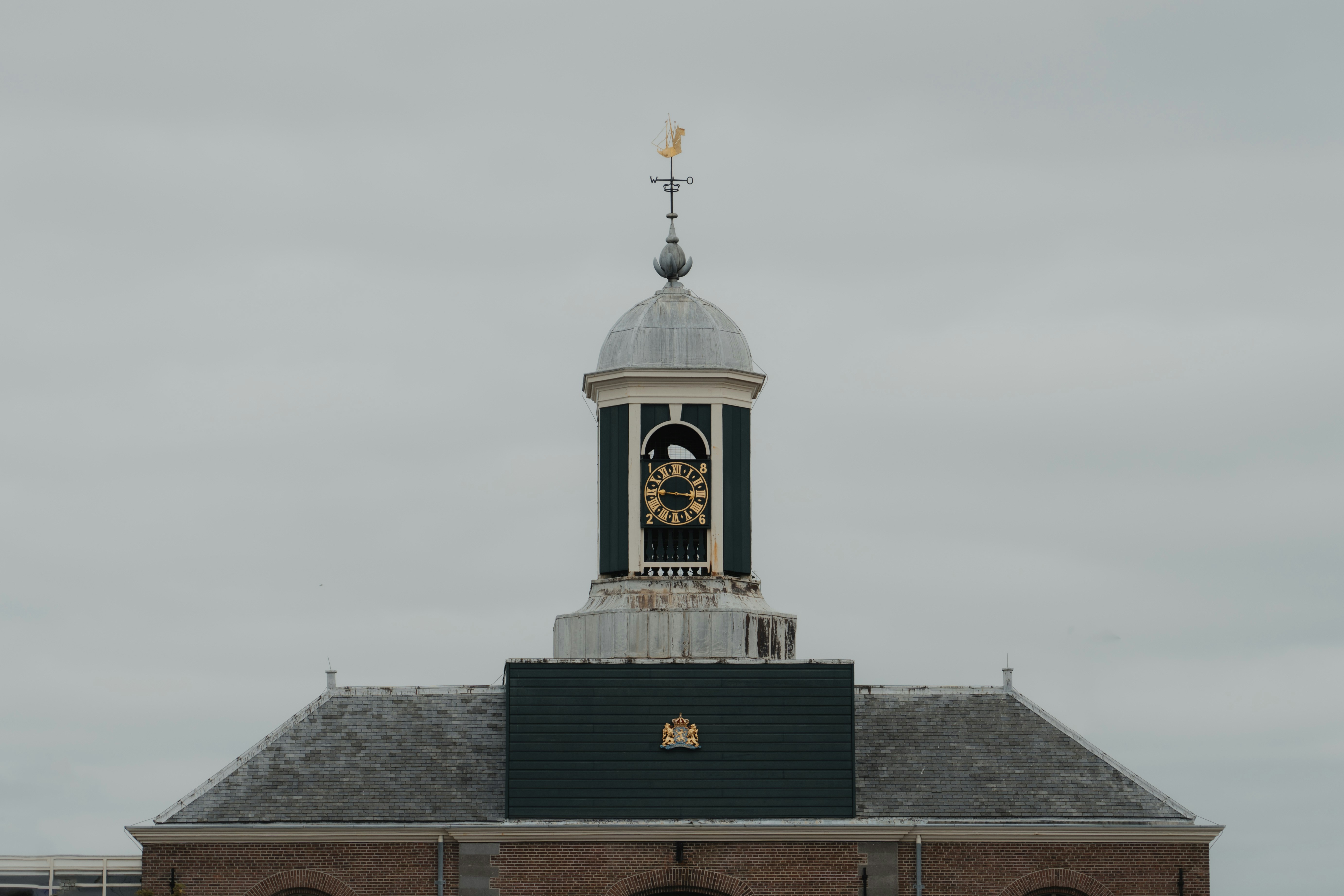 A clock tower on top of a building photo – Free Den helder Image on ...