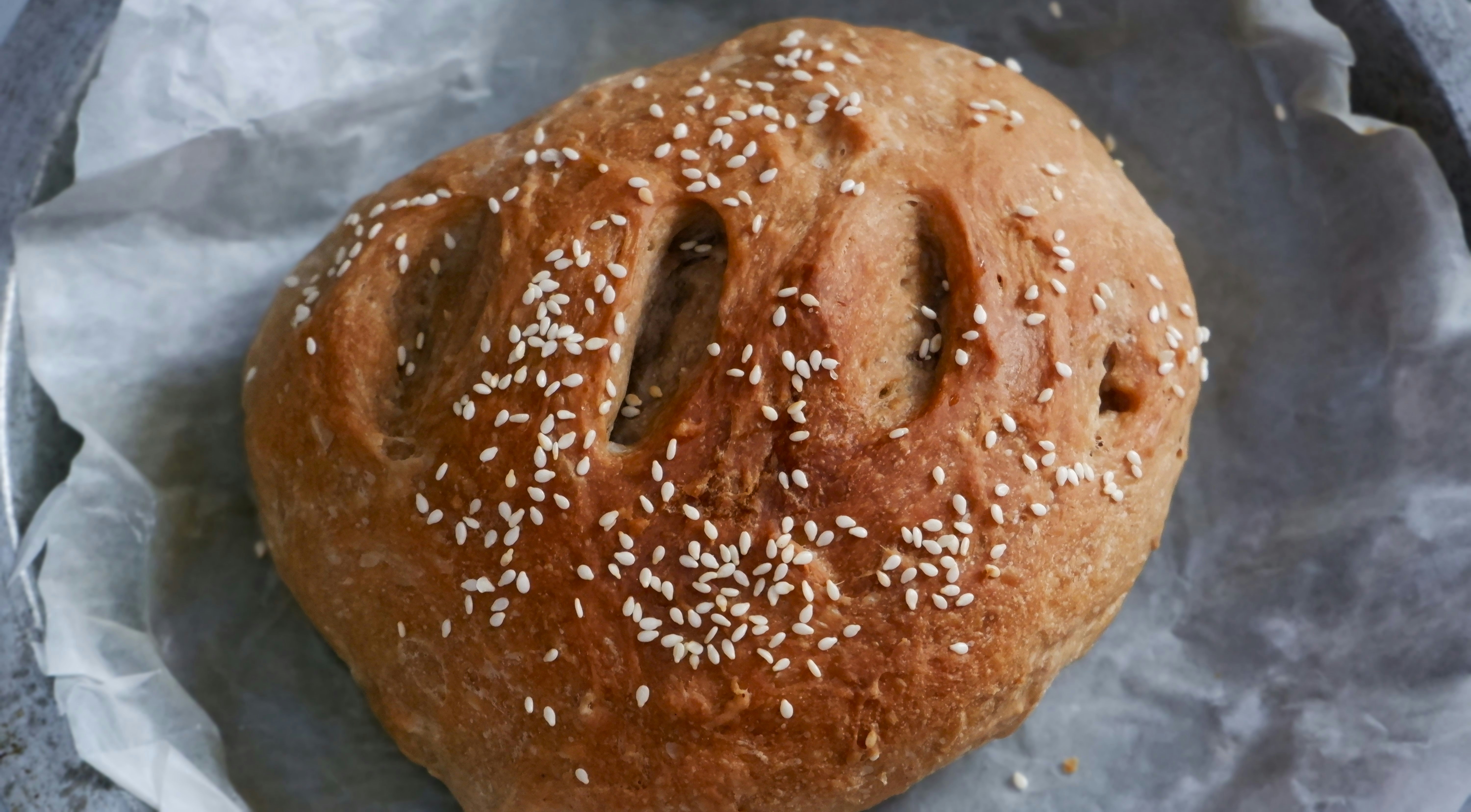 Golden Sesame Bun on Parchment: A Rustic Bakery Close-Up
