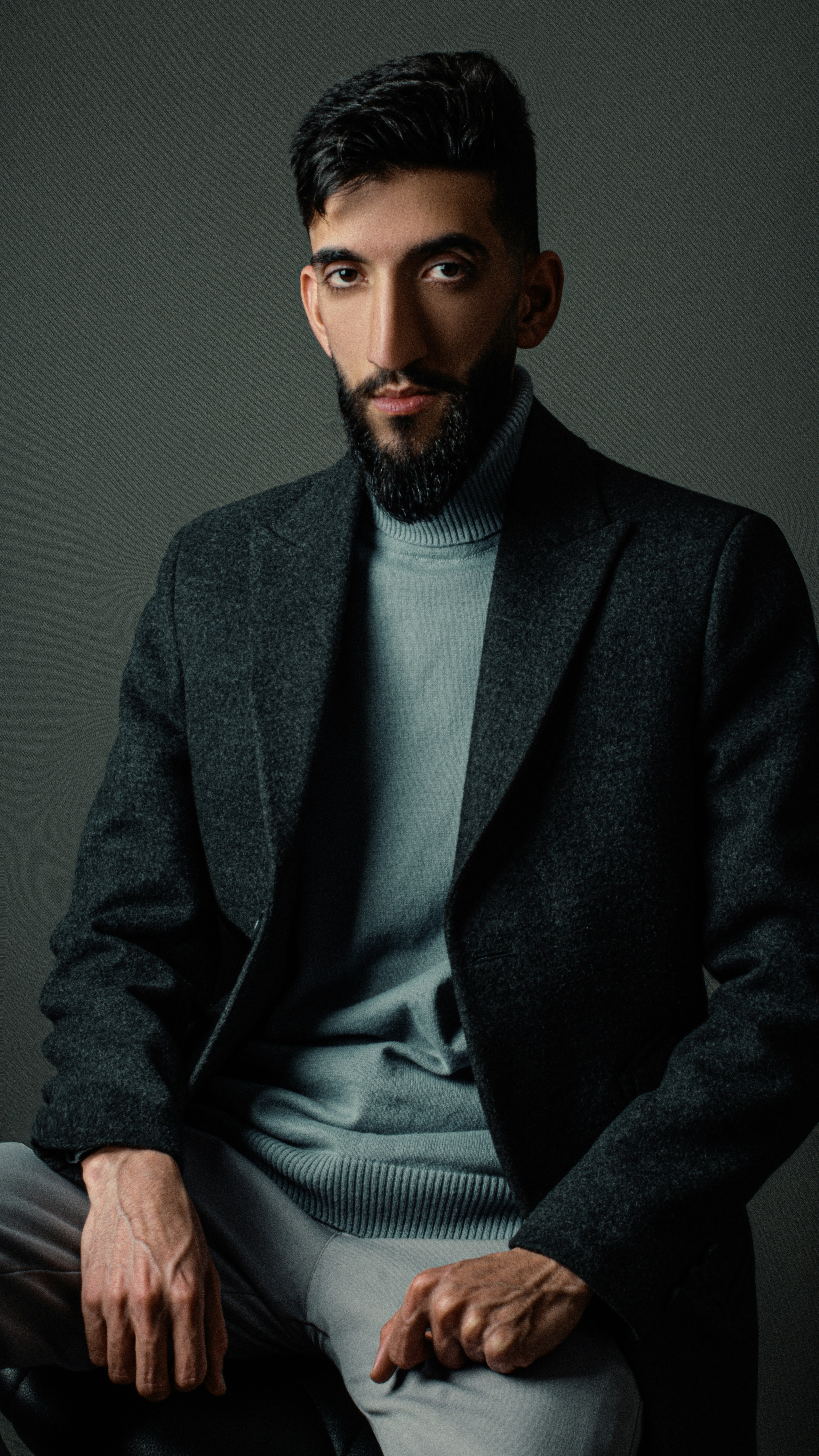 A man with a goatee and a beard sitting on a chair photo – Free Iran ...