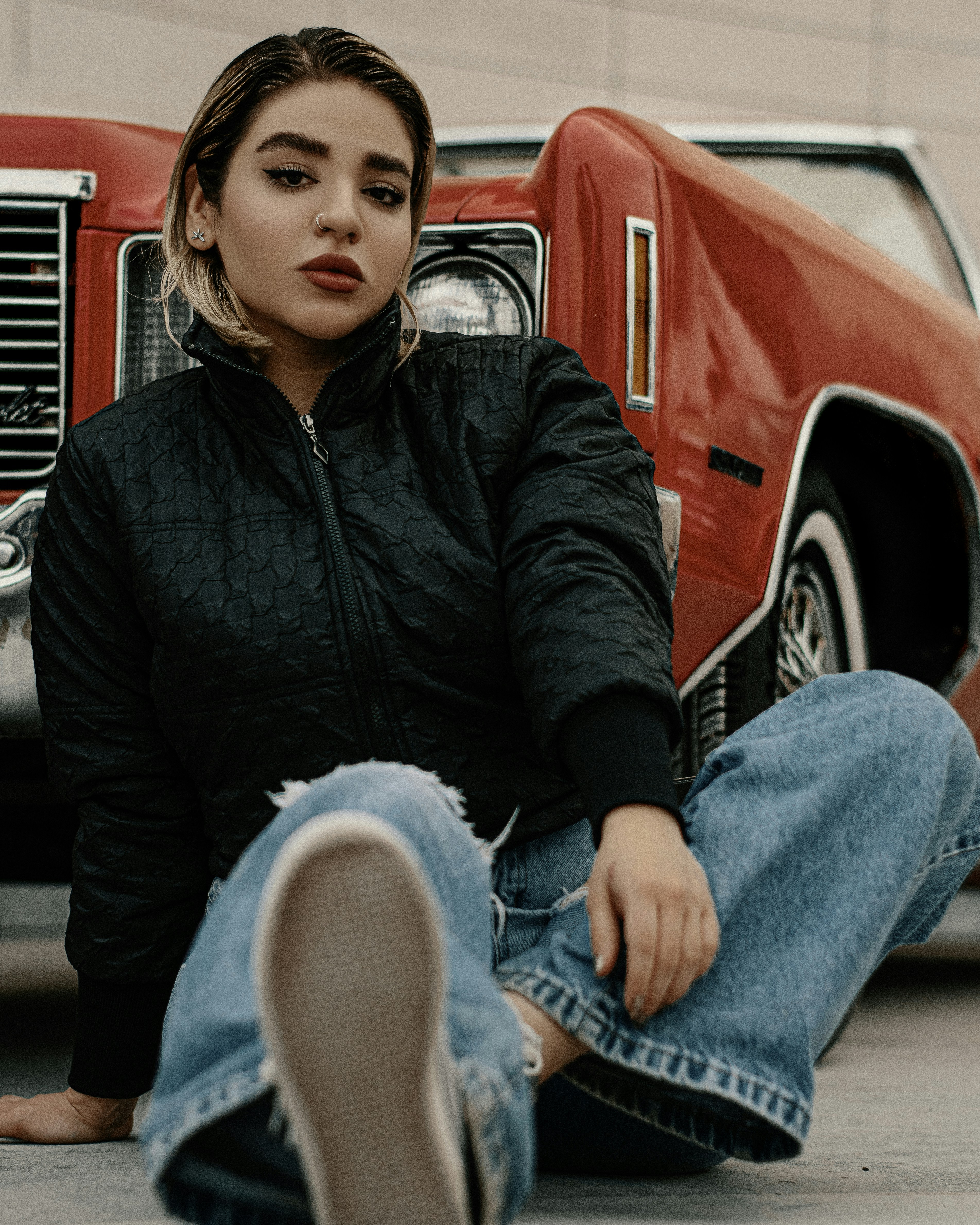 Red-Backlit Portrait: A Confident Moment by a Vintage Pickup