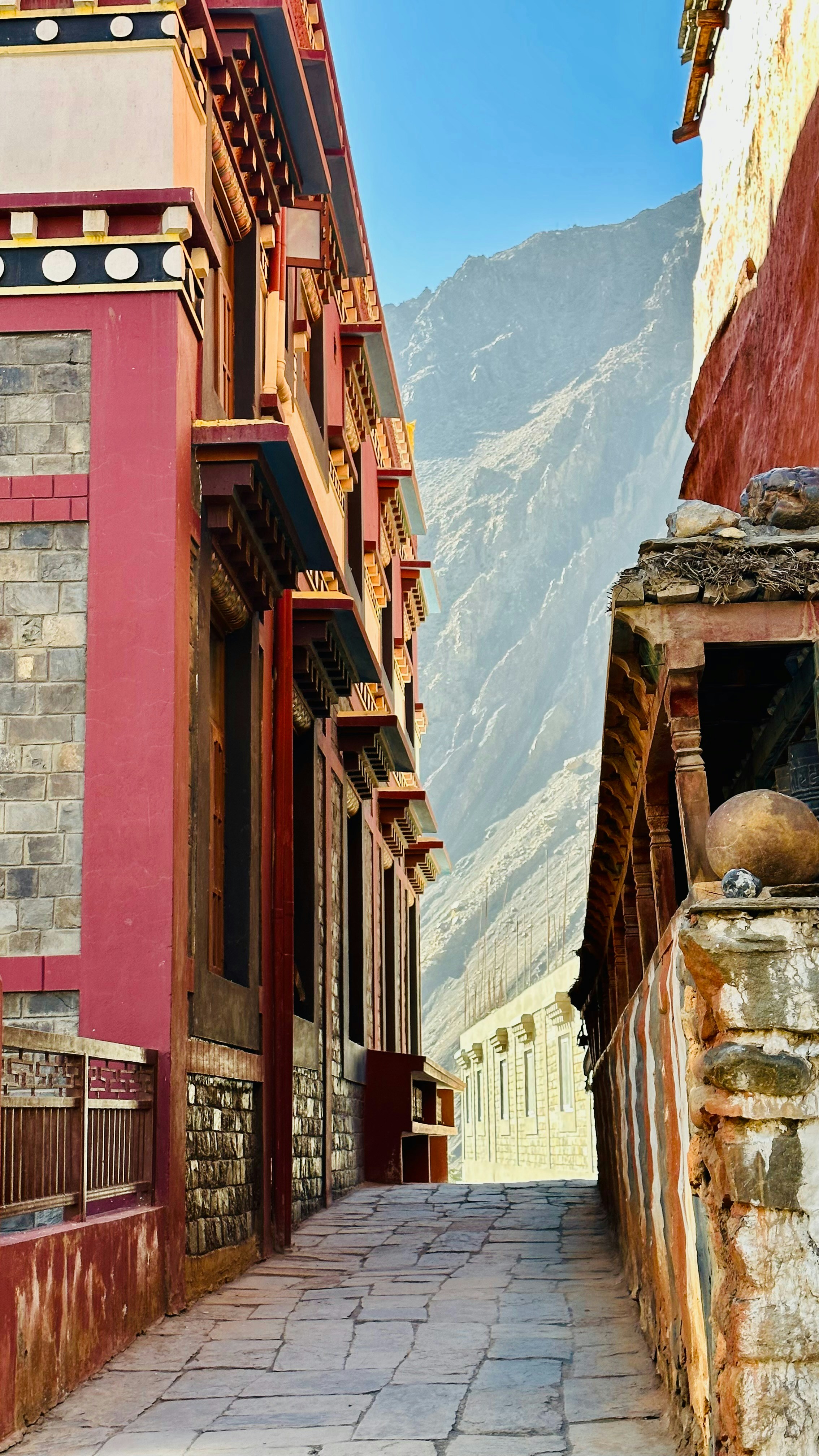 Maroon Facades Framing a Sunlit Mountain Pass