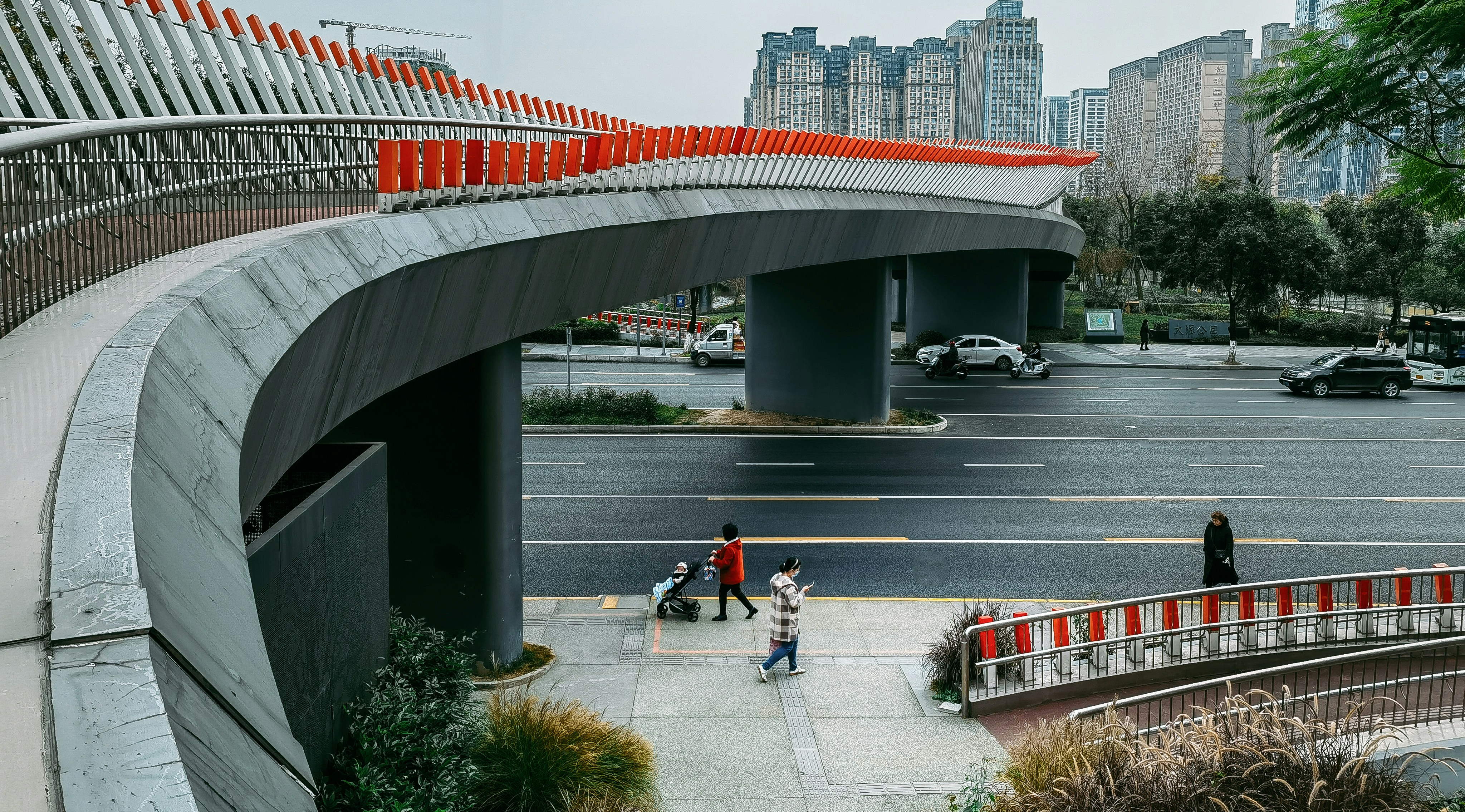 A group of people walking across a street under a bridge photo – Free ...