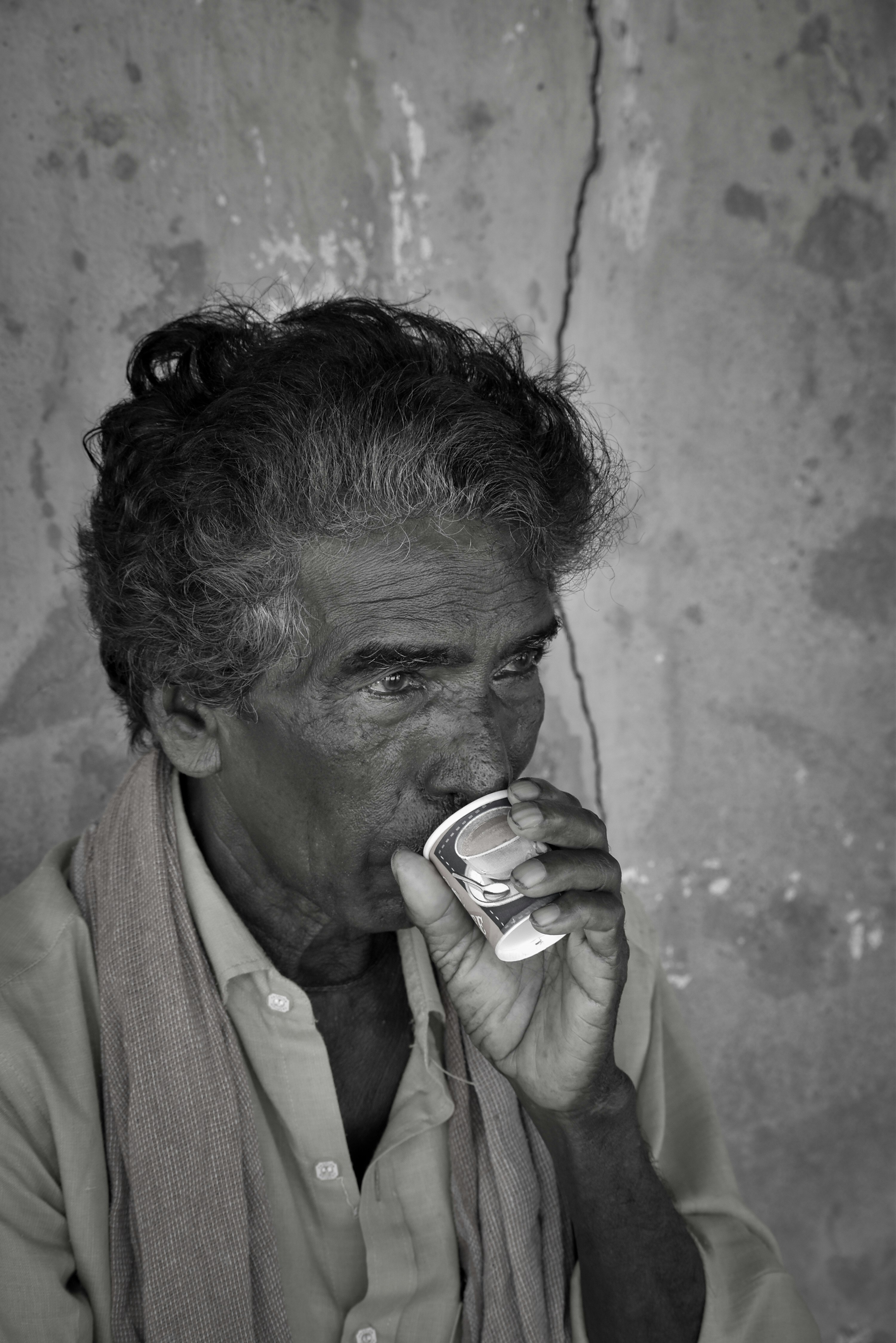 A black and white photo of a man drinking something photo – Free Labour ...
