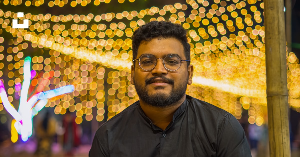 Un Hombre Sentado En Un Banco Con Muchas Luces De Fondo Foto Imagen