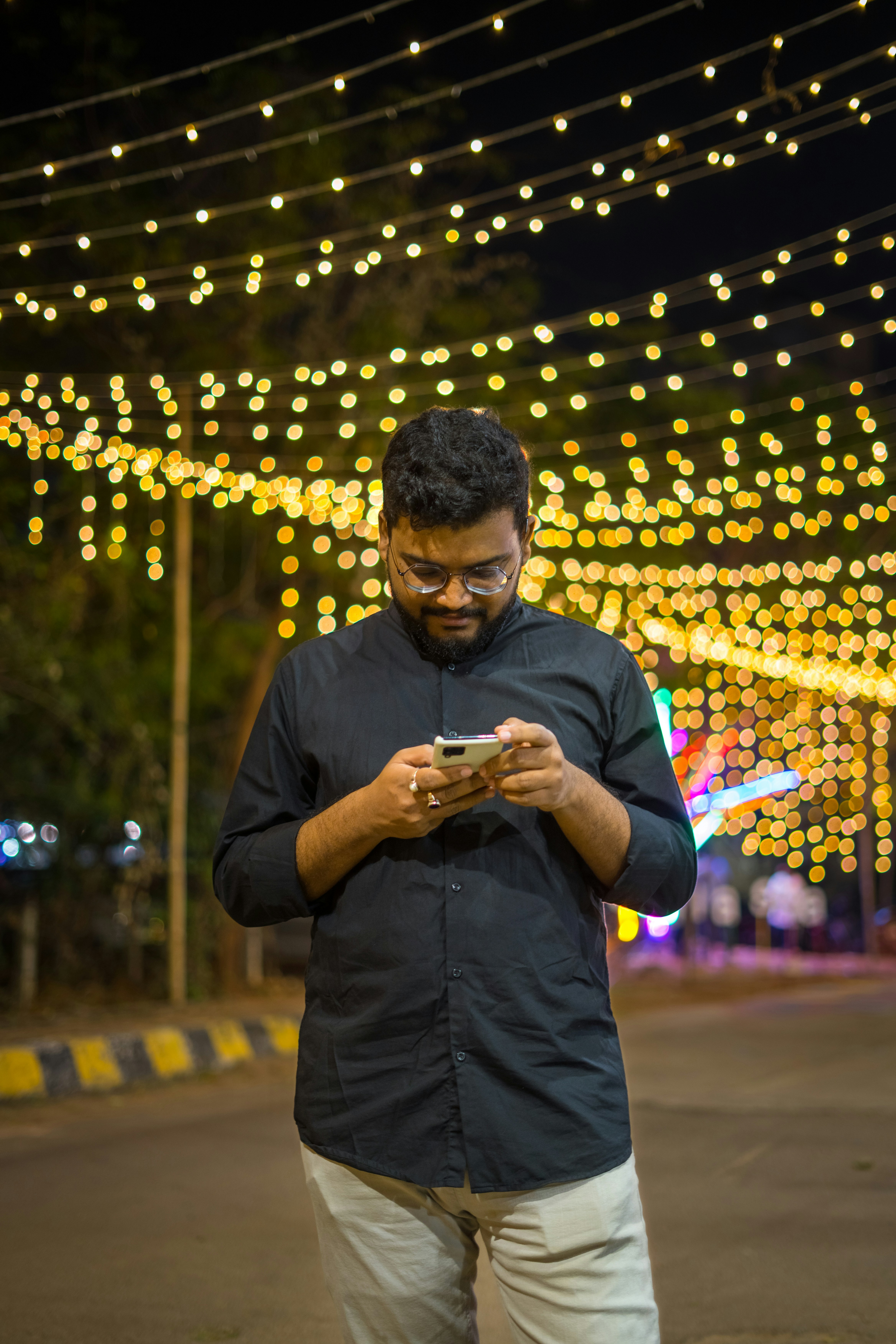 A man standing on a street looking at his cell phone photo – Free Photo ...