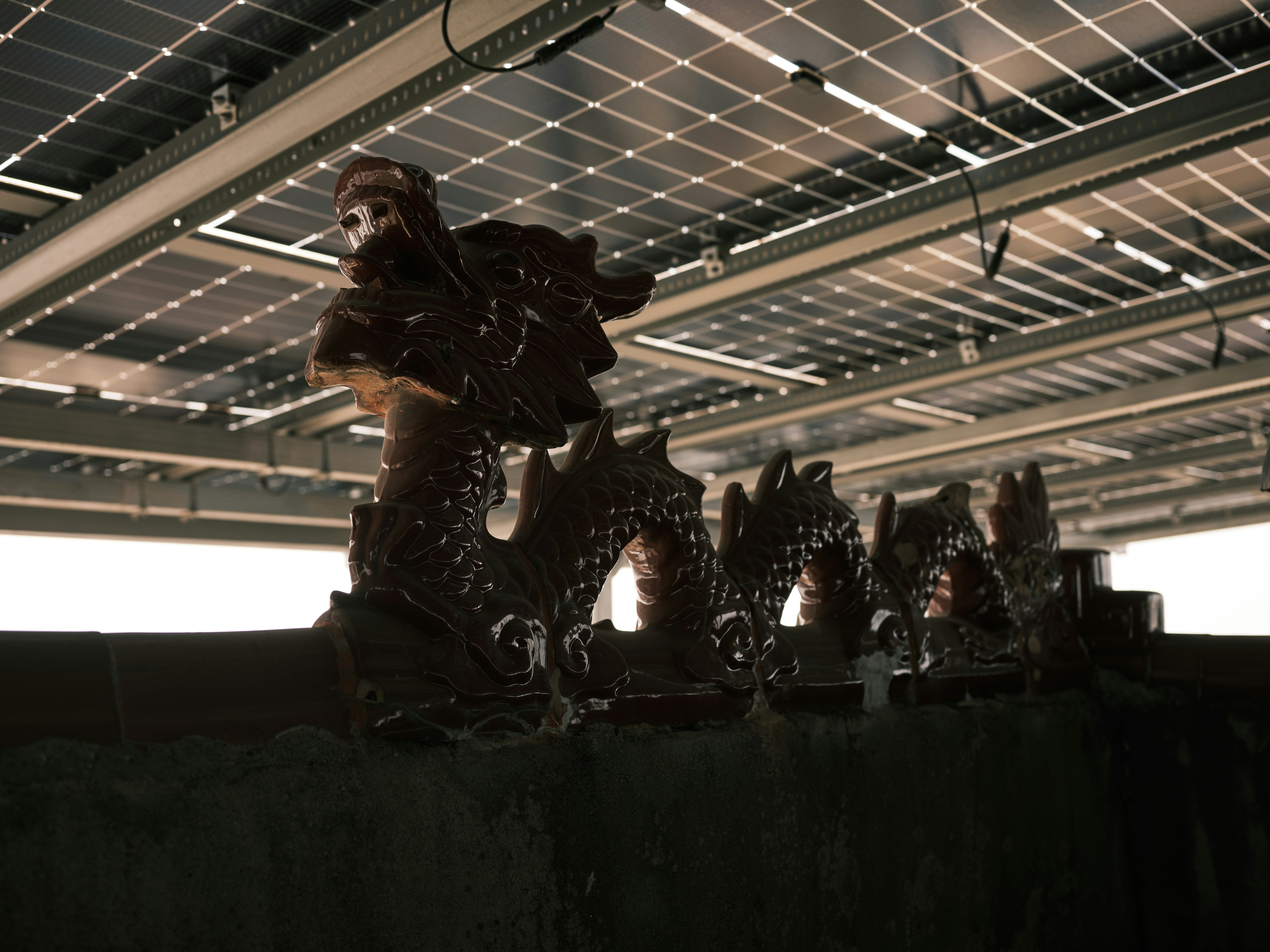 Guardians in Shadow: Dragon Heads Guard a Rail Under an Industrial Grid
