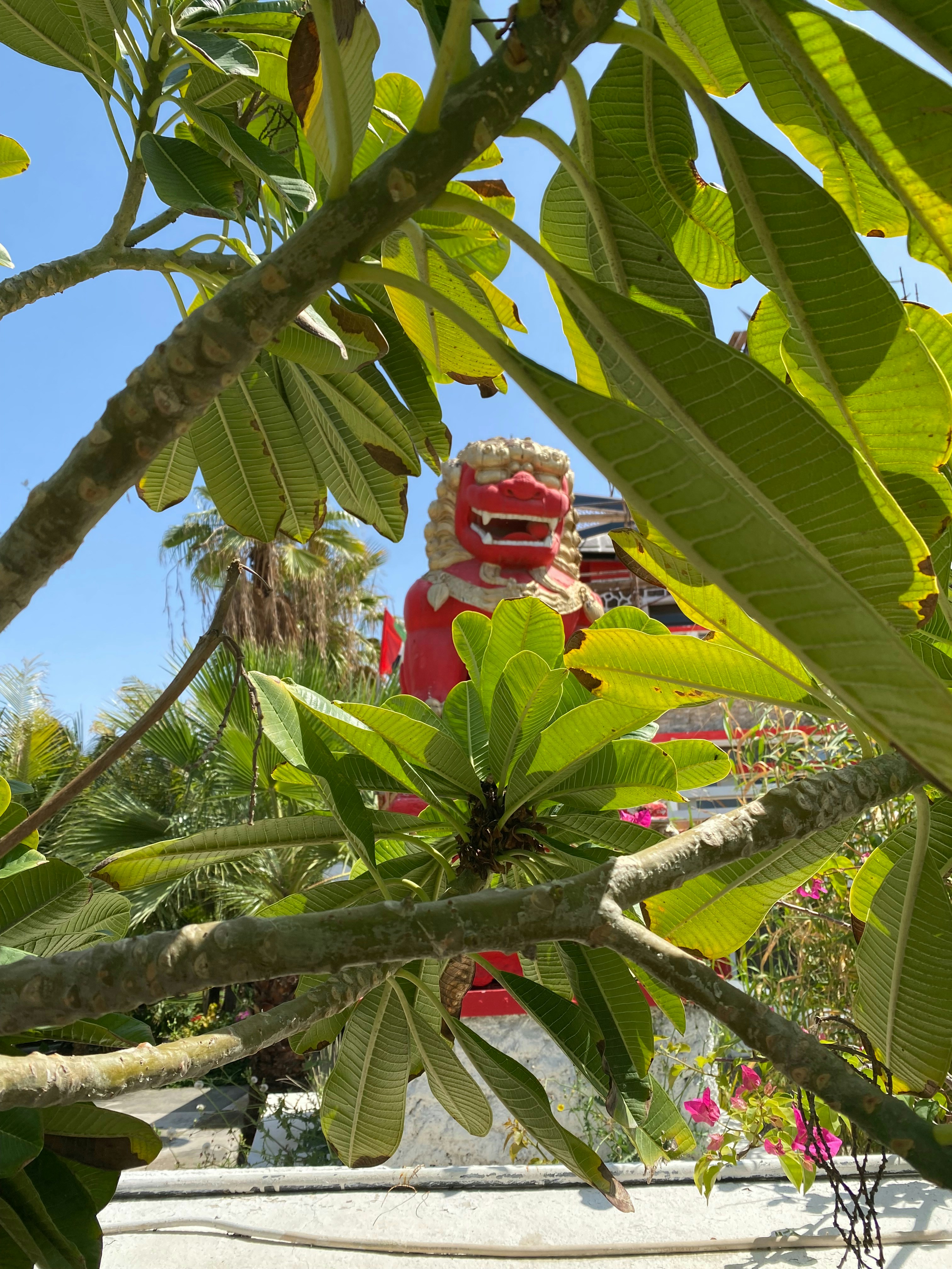 Red Guardian Among Leaves: A Hidden Shrine of Color