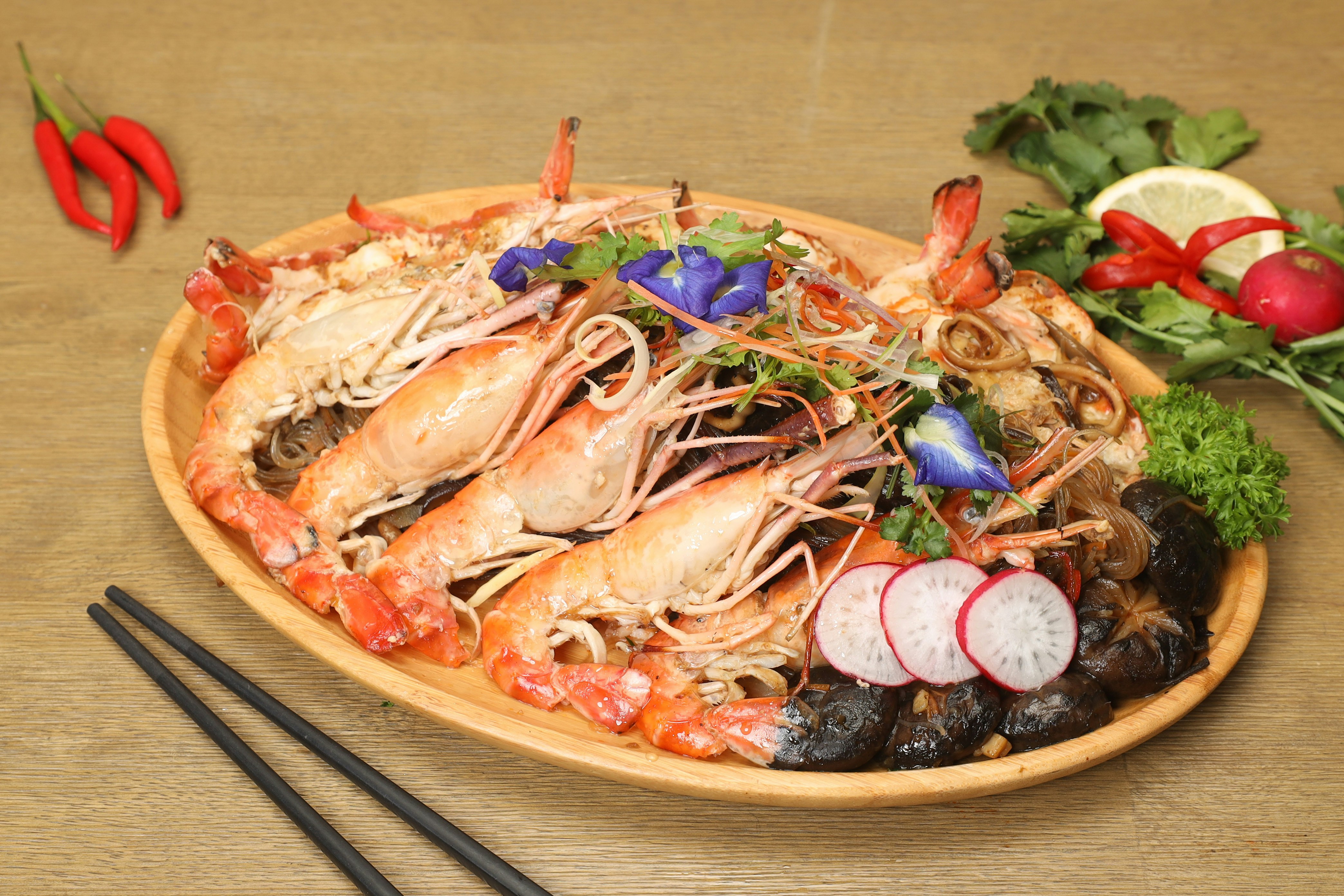 A beautifully arranged platter of seafood featuring large shrimp, shellfish, and vibrant garnishes, showcasing a feast for the senses.