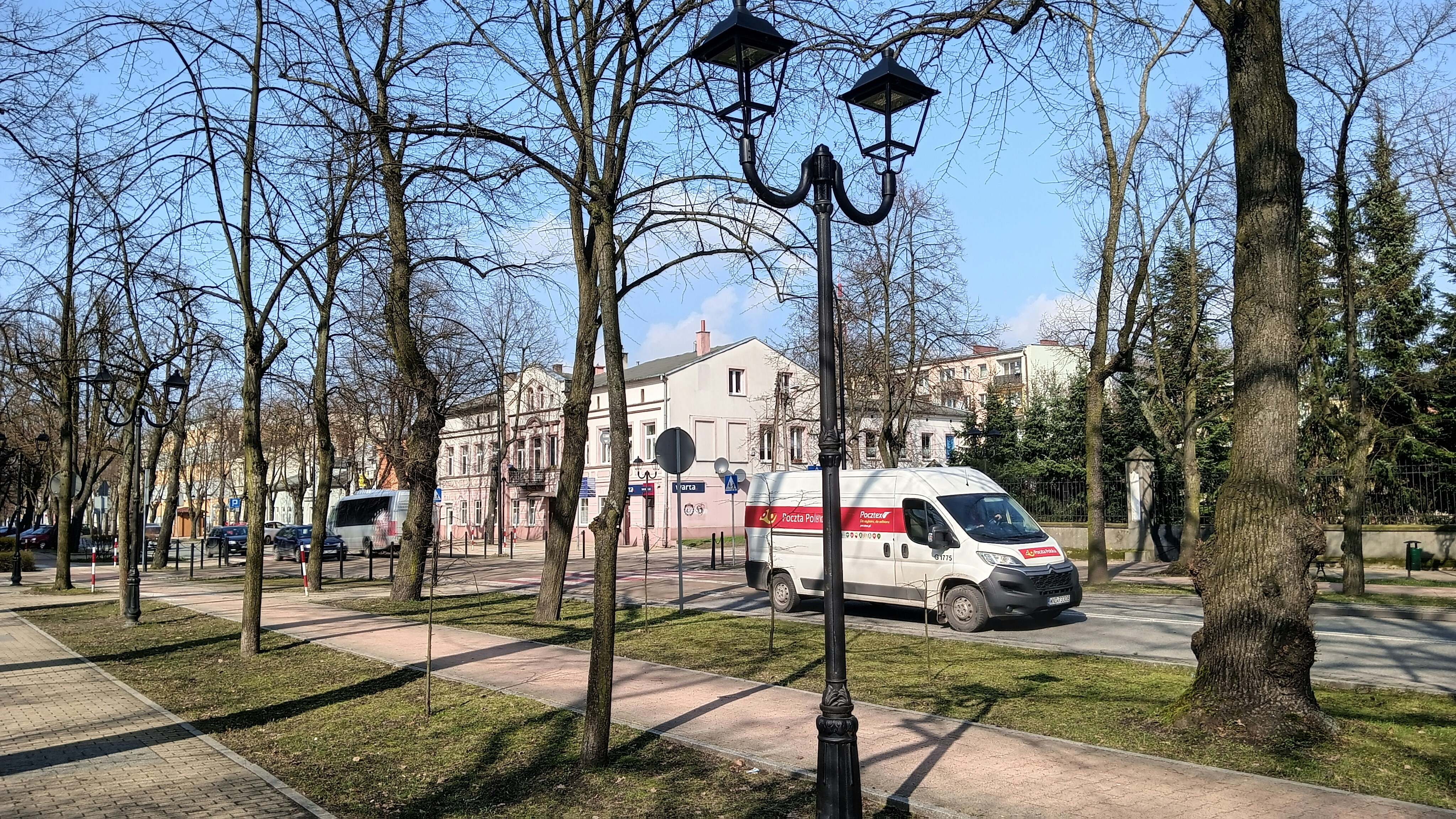 Ambulance Threading a Tree-Lined City Street by the Park