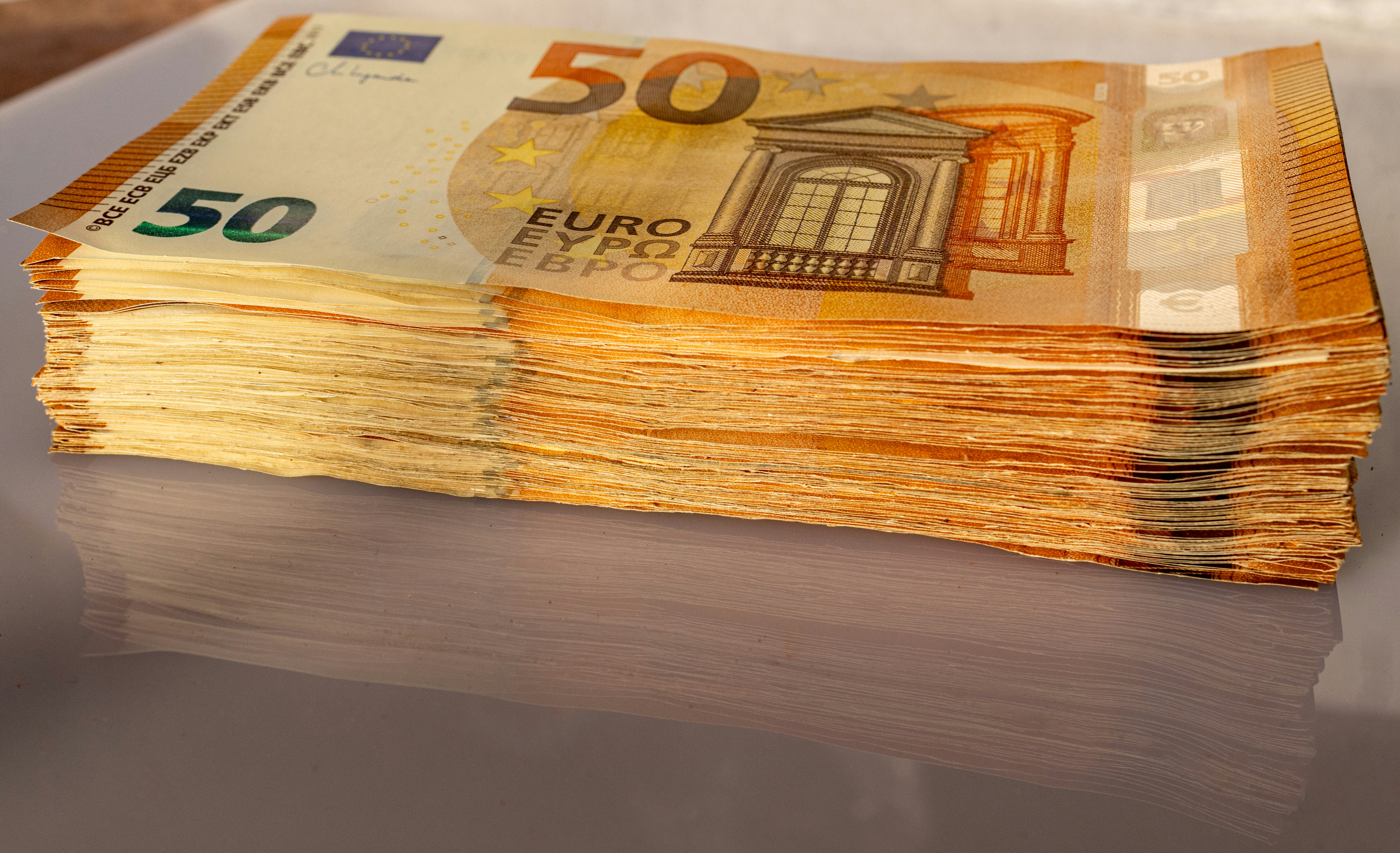 A stack of 50 euro bills sitting on top of a table photo – Free Money ...