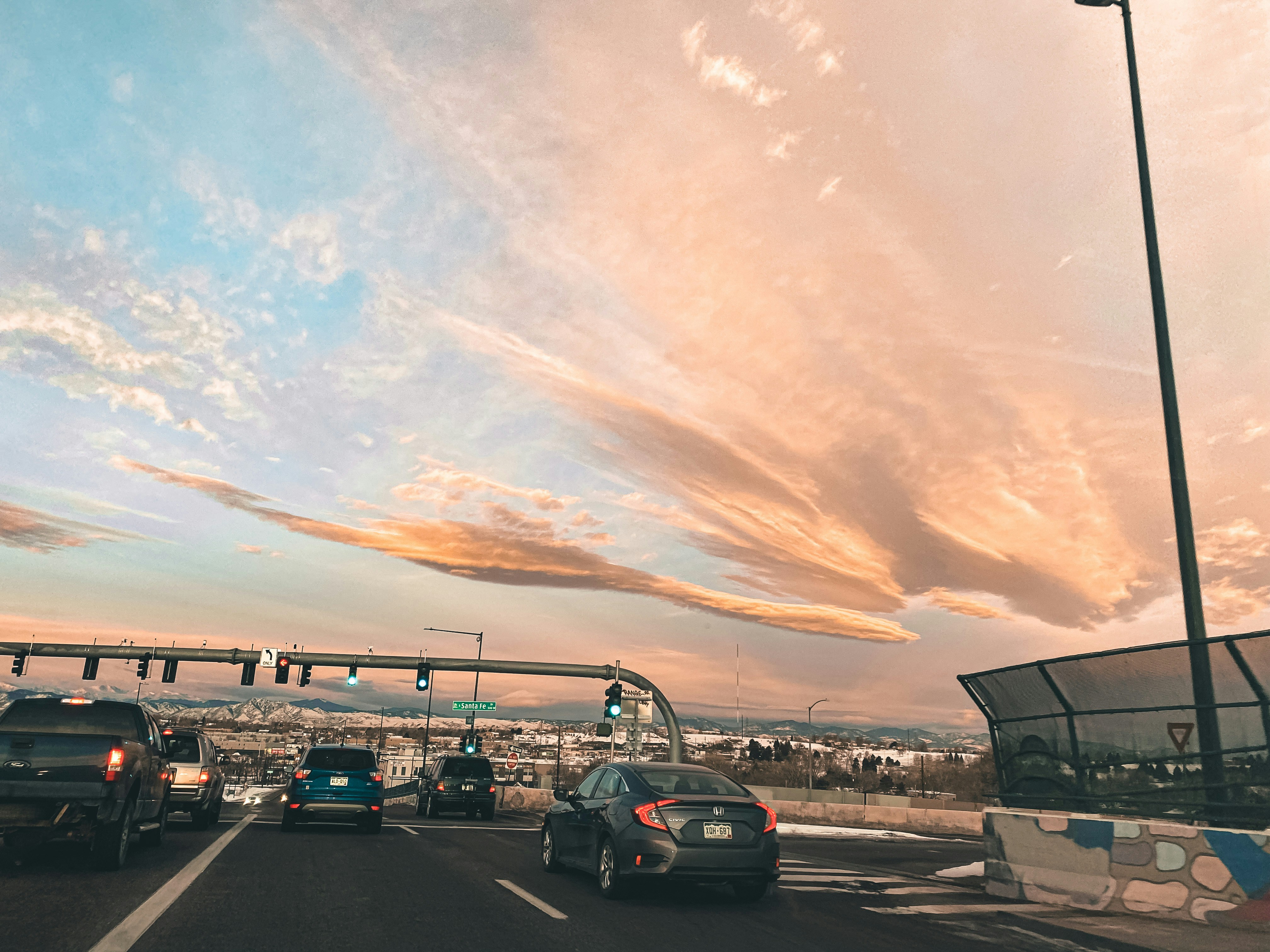 Coral Clouds Over a Parking Lot: Dusk Lineup of Cars