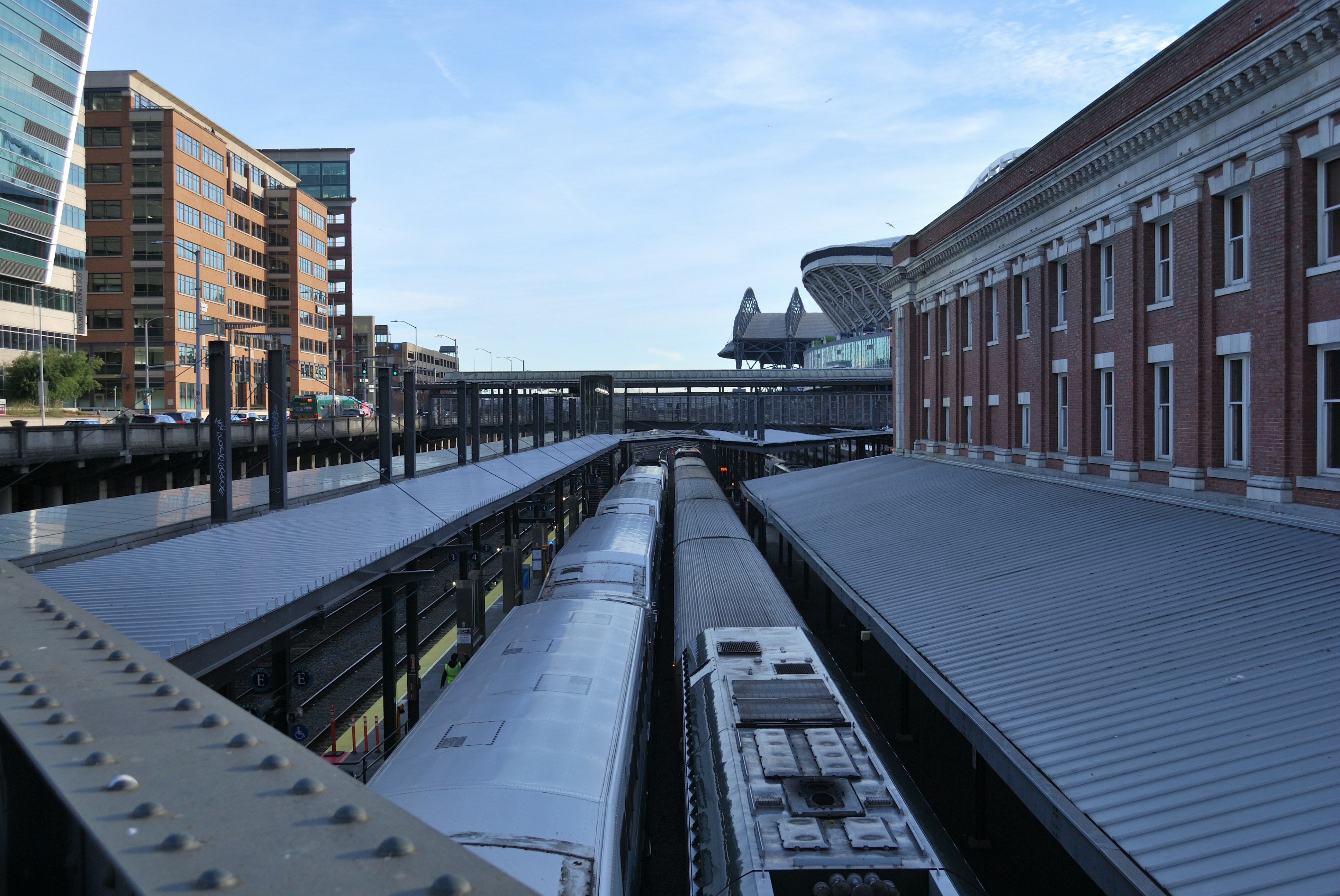 Foto Un tren que viaja por las vías del tren junto a edificios altos – Imagen Terminal gratis en ...