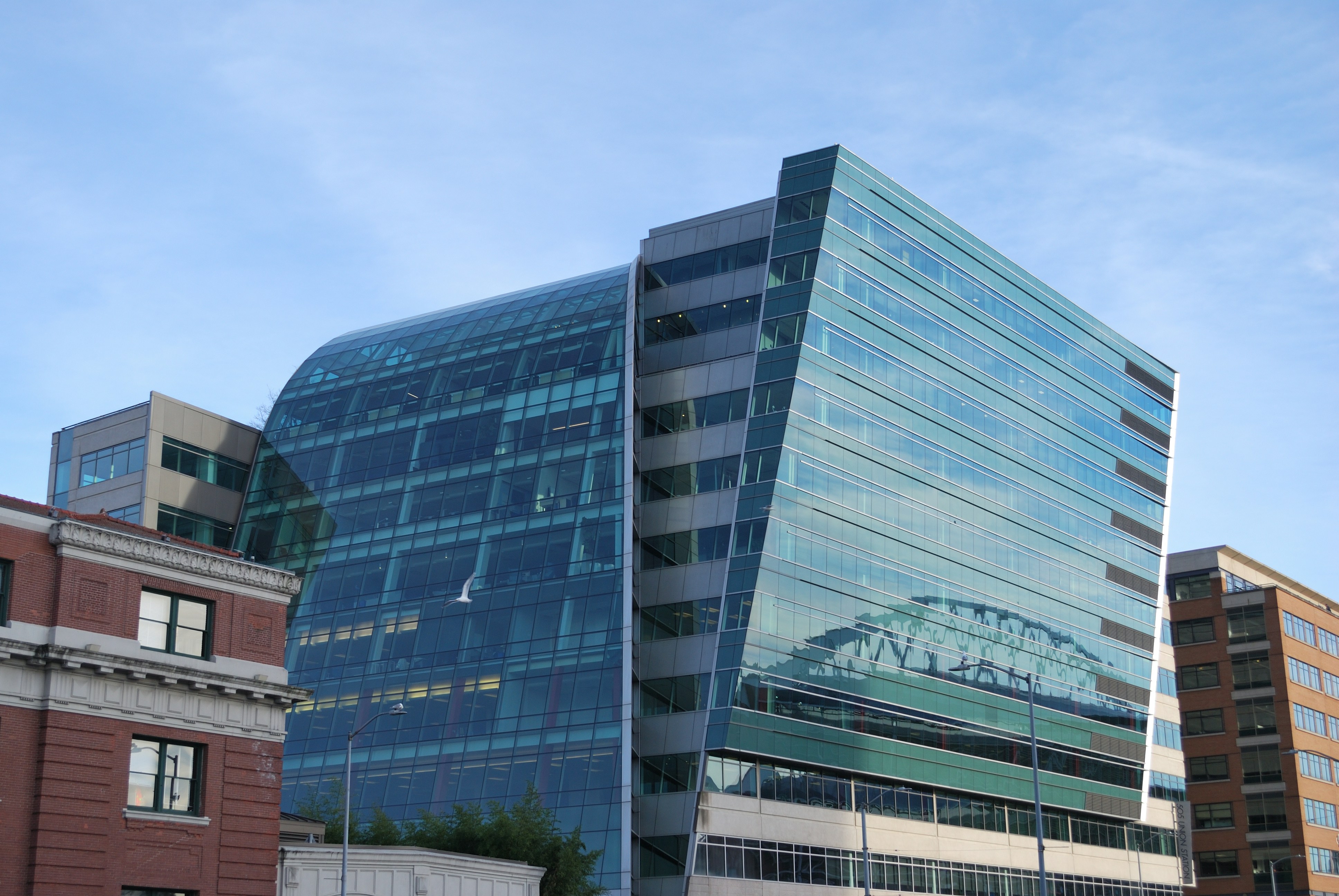 Contemporary office building with a striking curved glass facade reflecting the urban landscape.