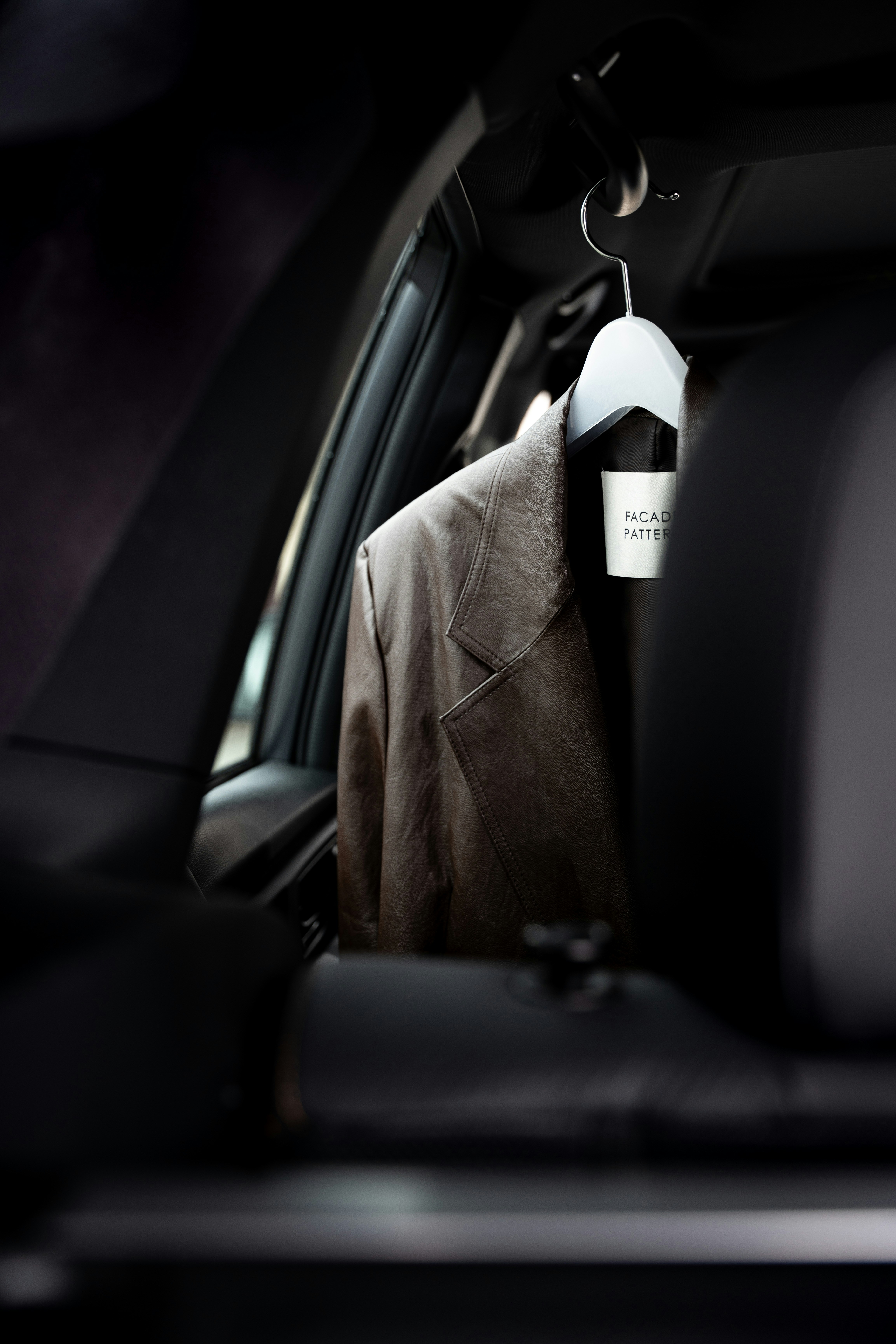 Hanger in the Backseat: A Minimalist Jacket on a White Hanger