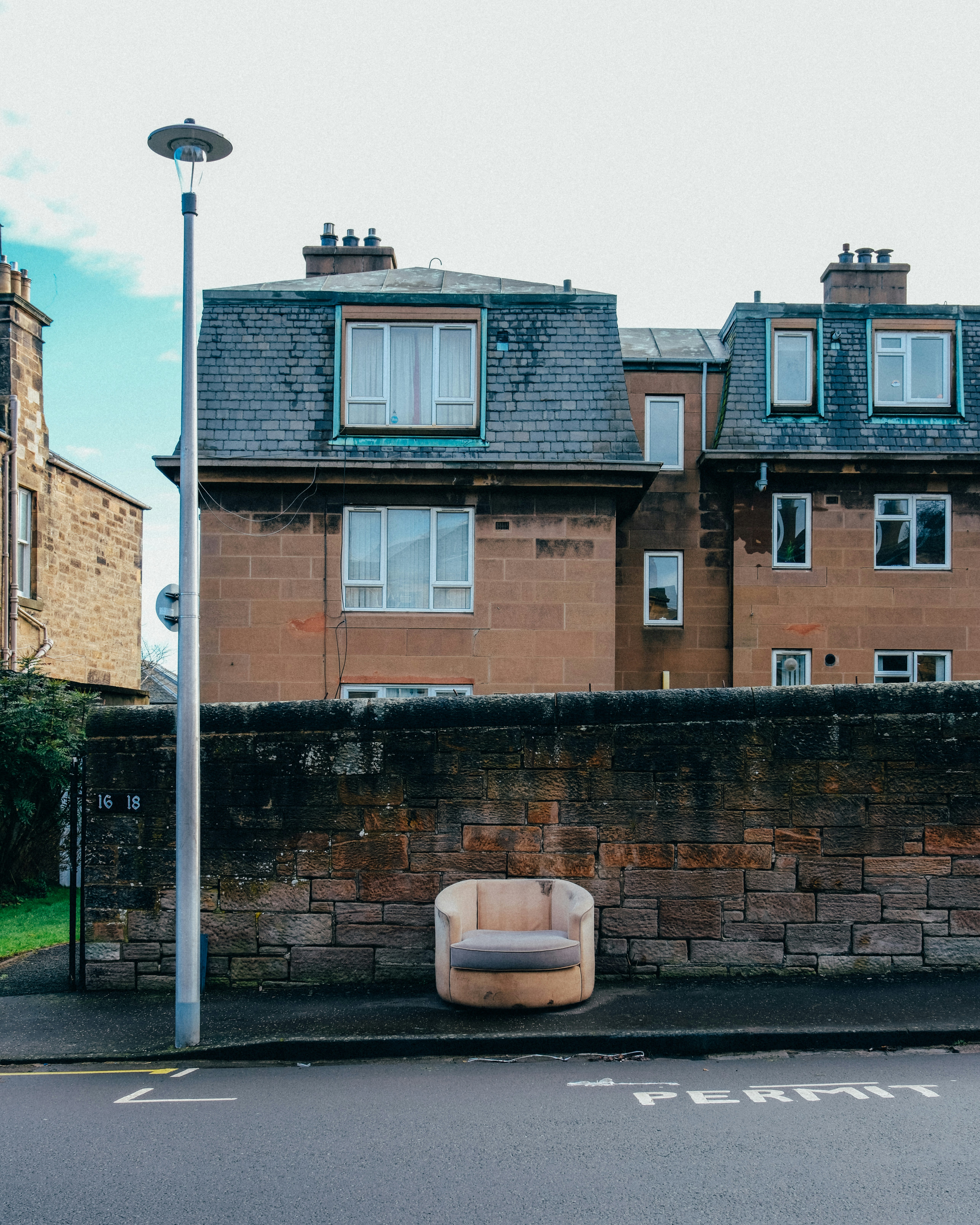 Couch by the Wall: A Quiet Street Scene in Stone and Brick