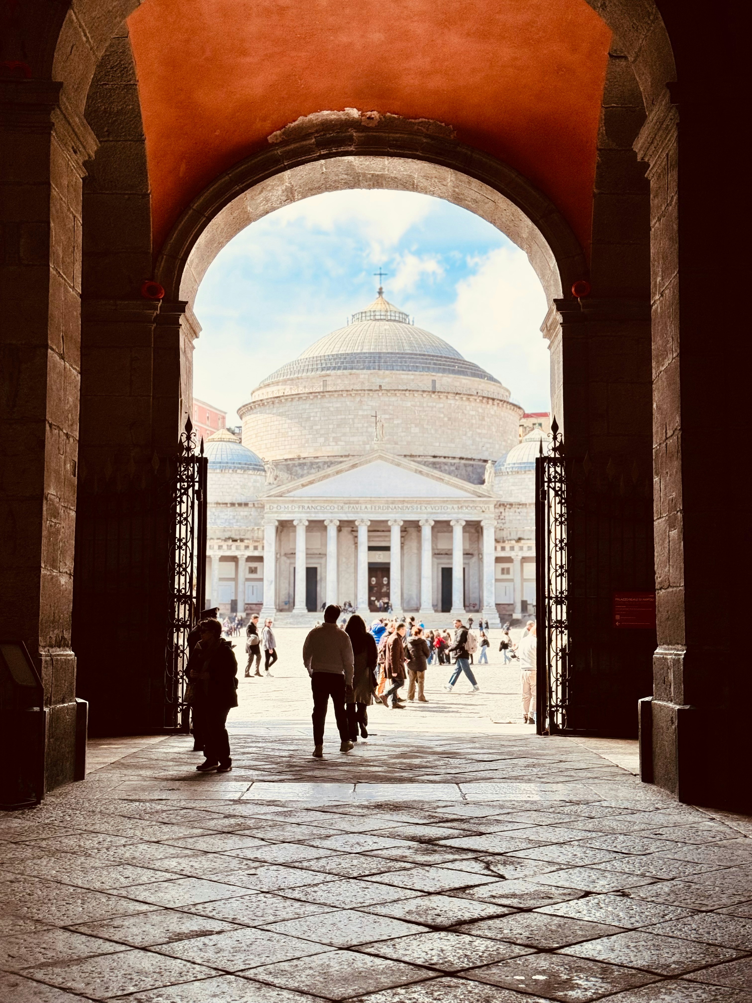 Eine Gruppe von Menschen, die unter einem Torbogen hindurchgehen Foto ...