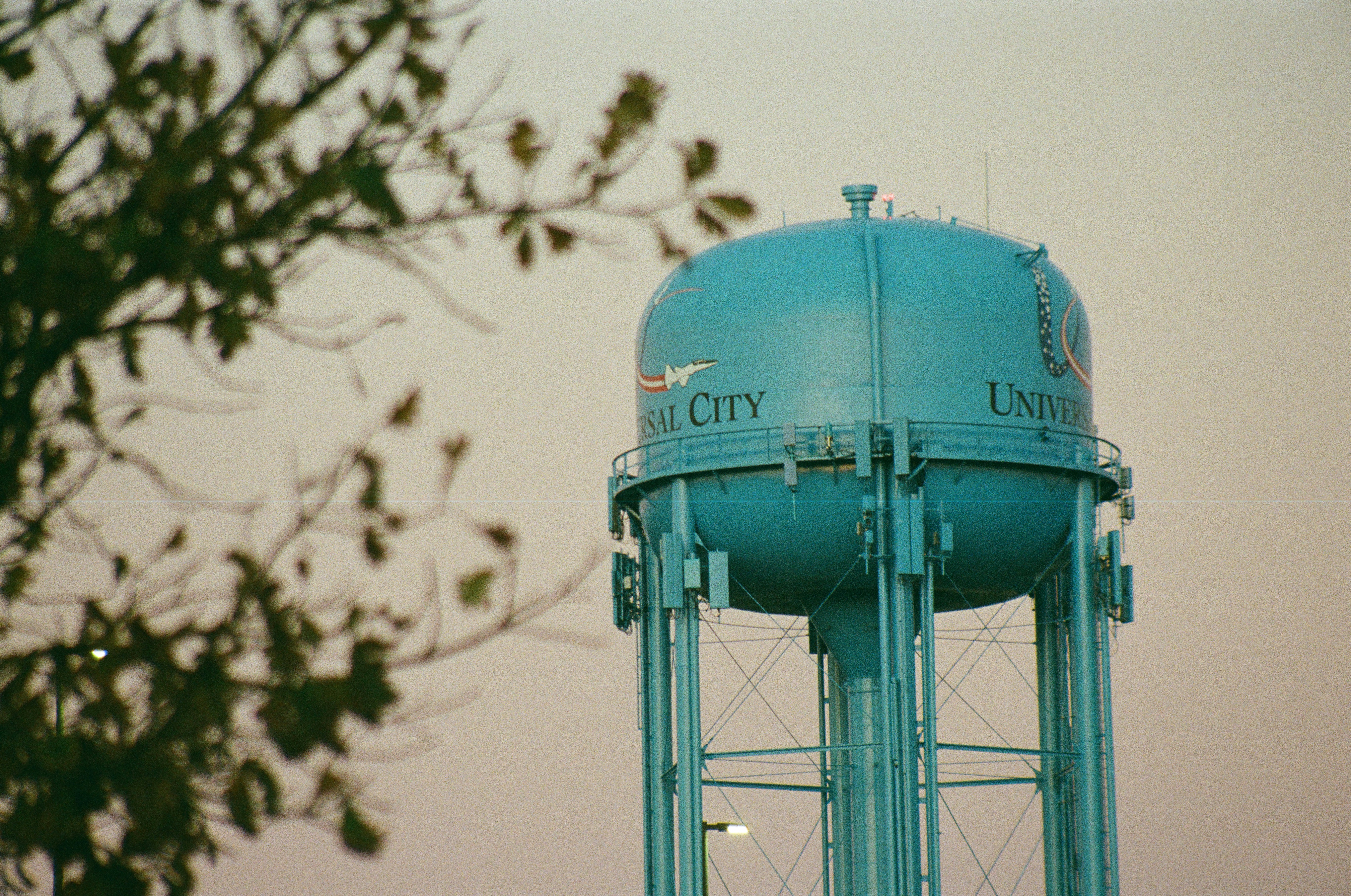 A large blue water tower sitting next to a tree photo – Free ...