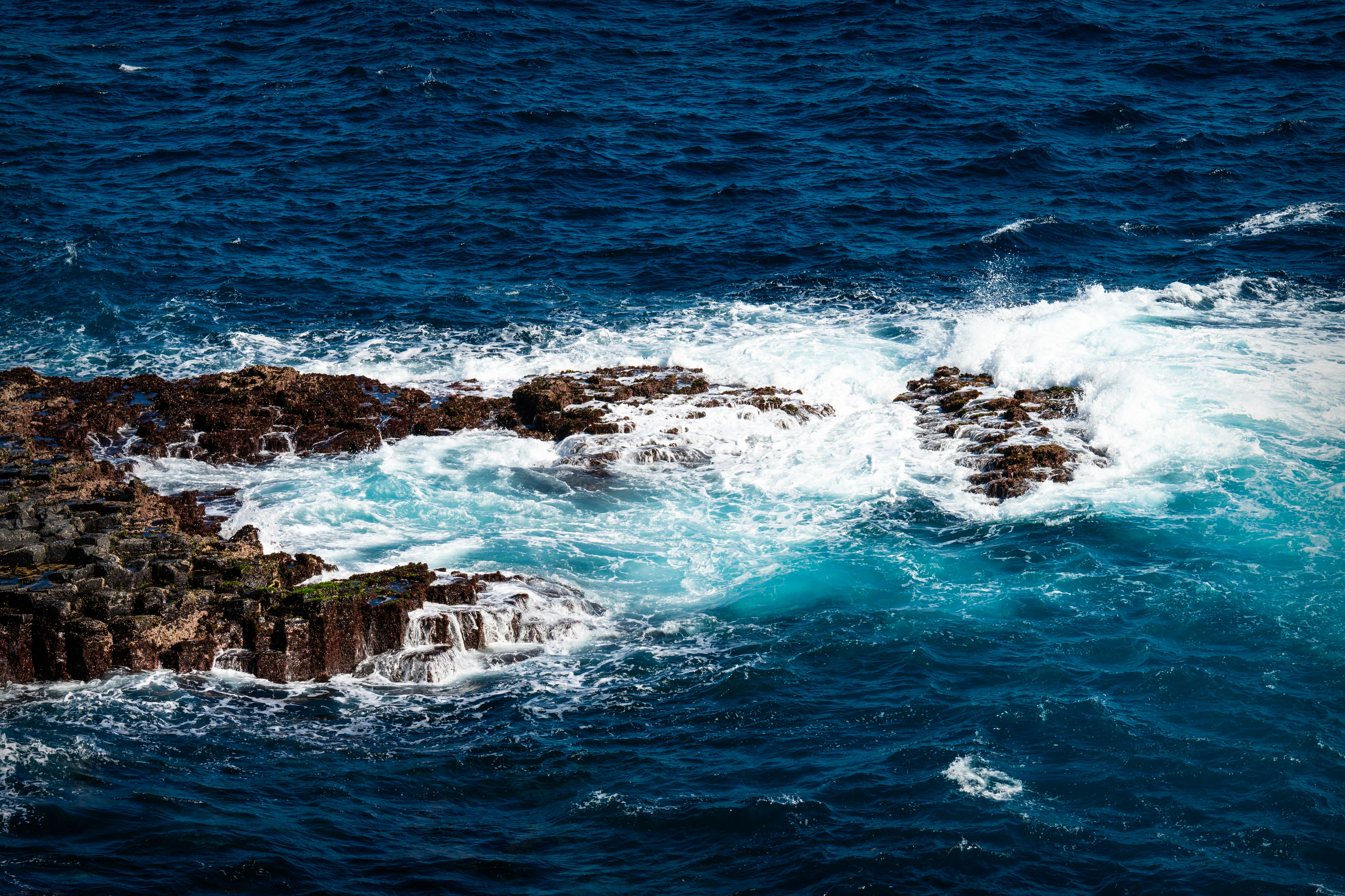A large body of water next to a rocky shore photo – Free Sea Image on ...