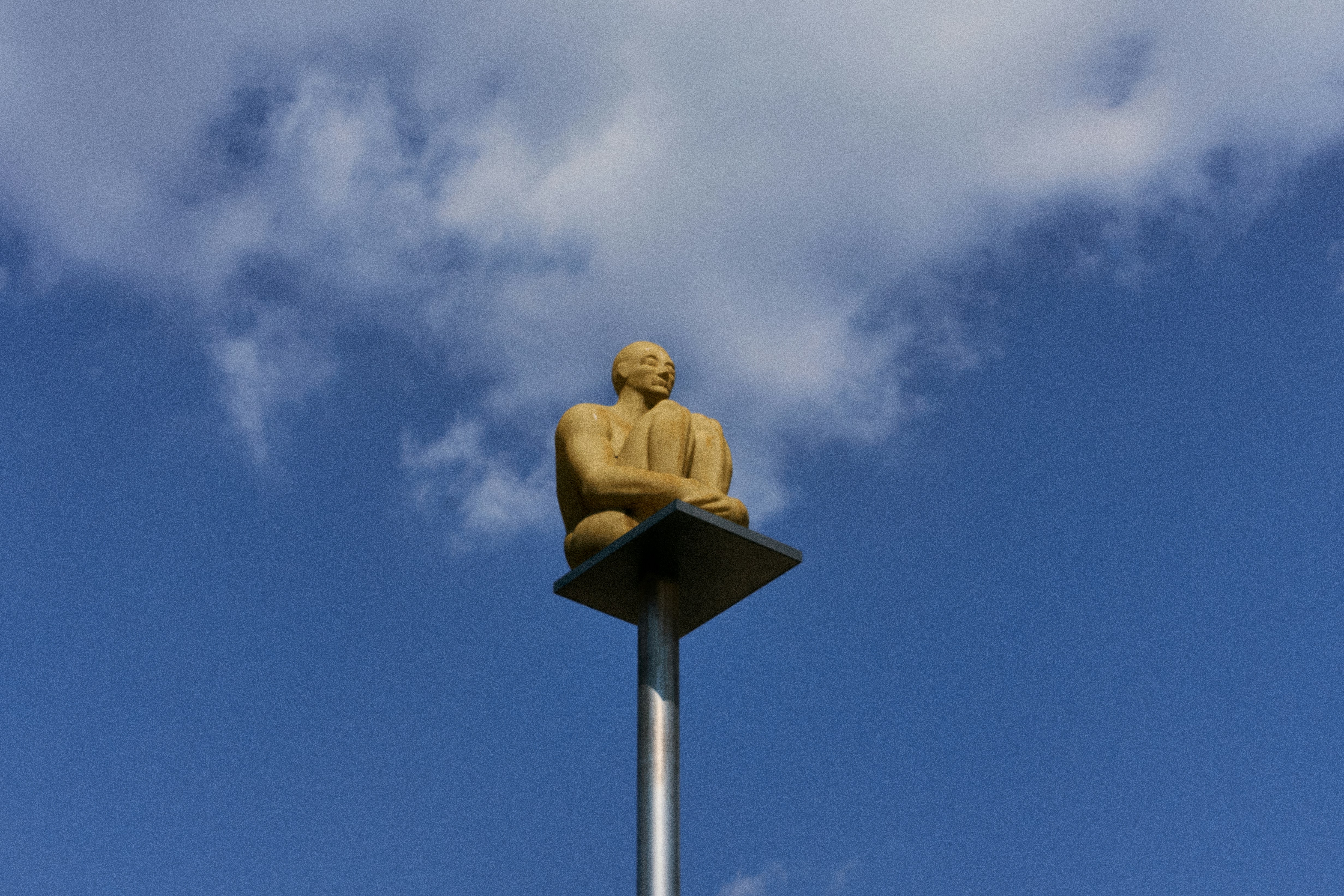 Seated Bronze Guardian on a Skyward Pole