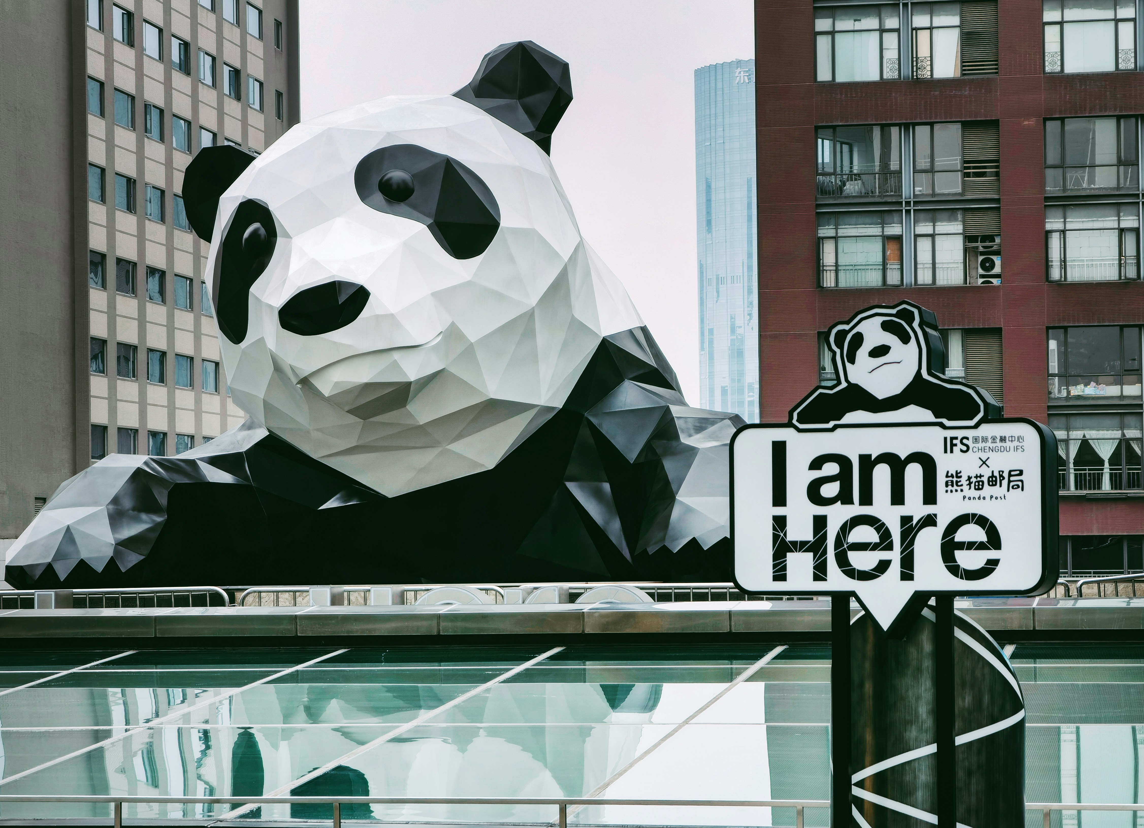 Geometric Panda Awakens the City: A Giant Sculpture Above Glass and Brick