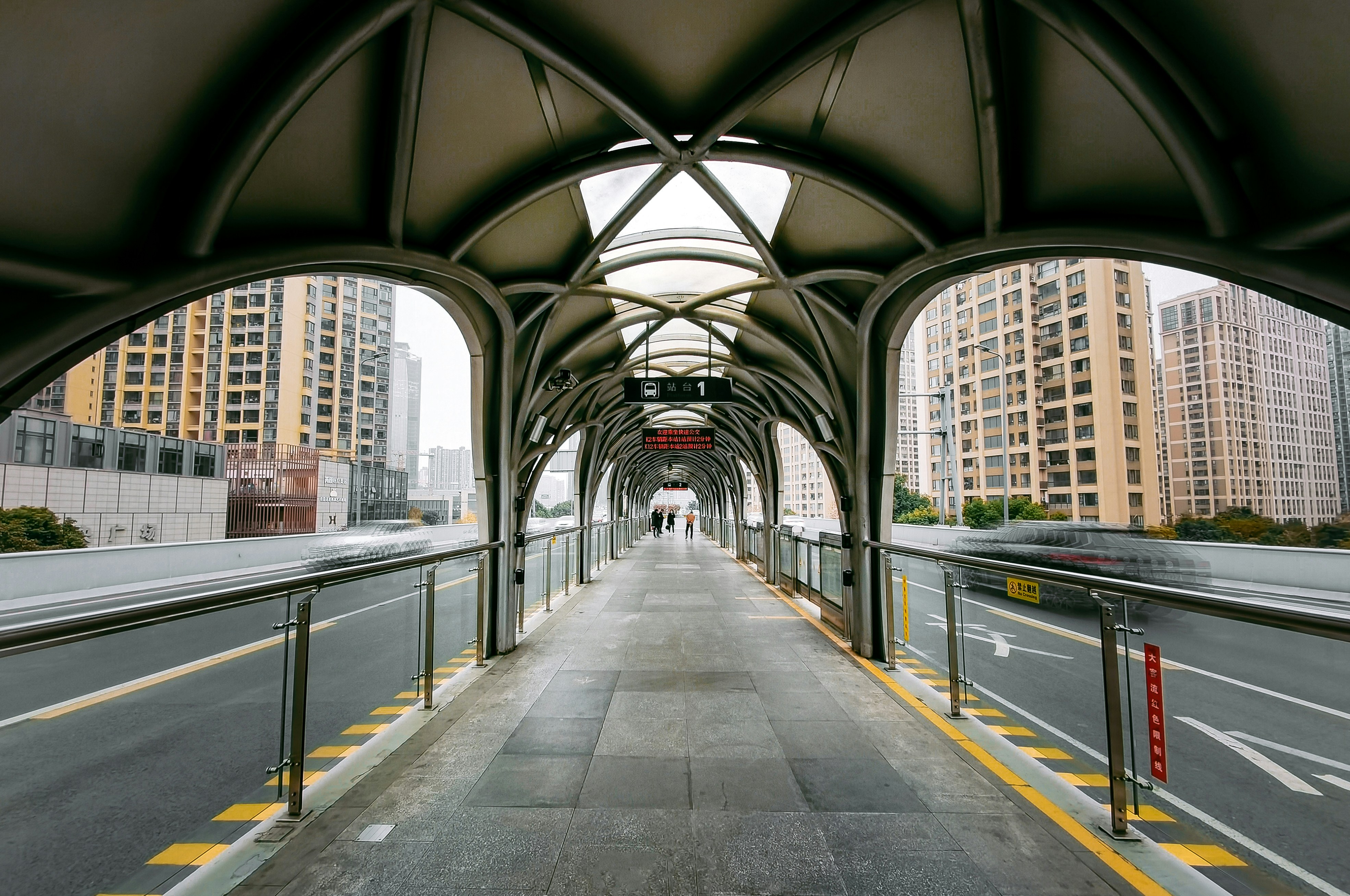 A train station with a walkway between two buildings photo – Free ...