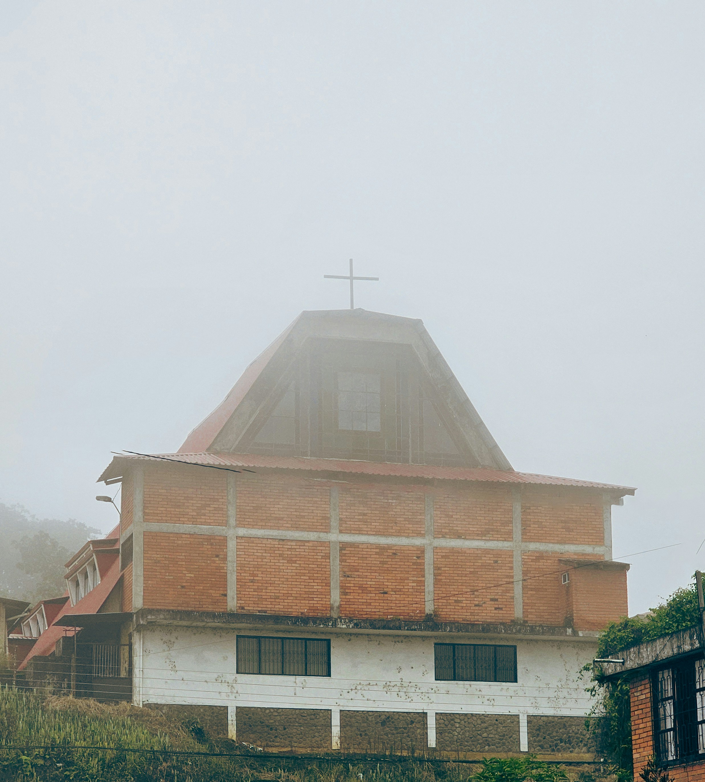 Cross in the Mist: A Brick Chapel Emerges Through Morning Fog