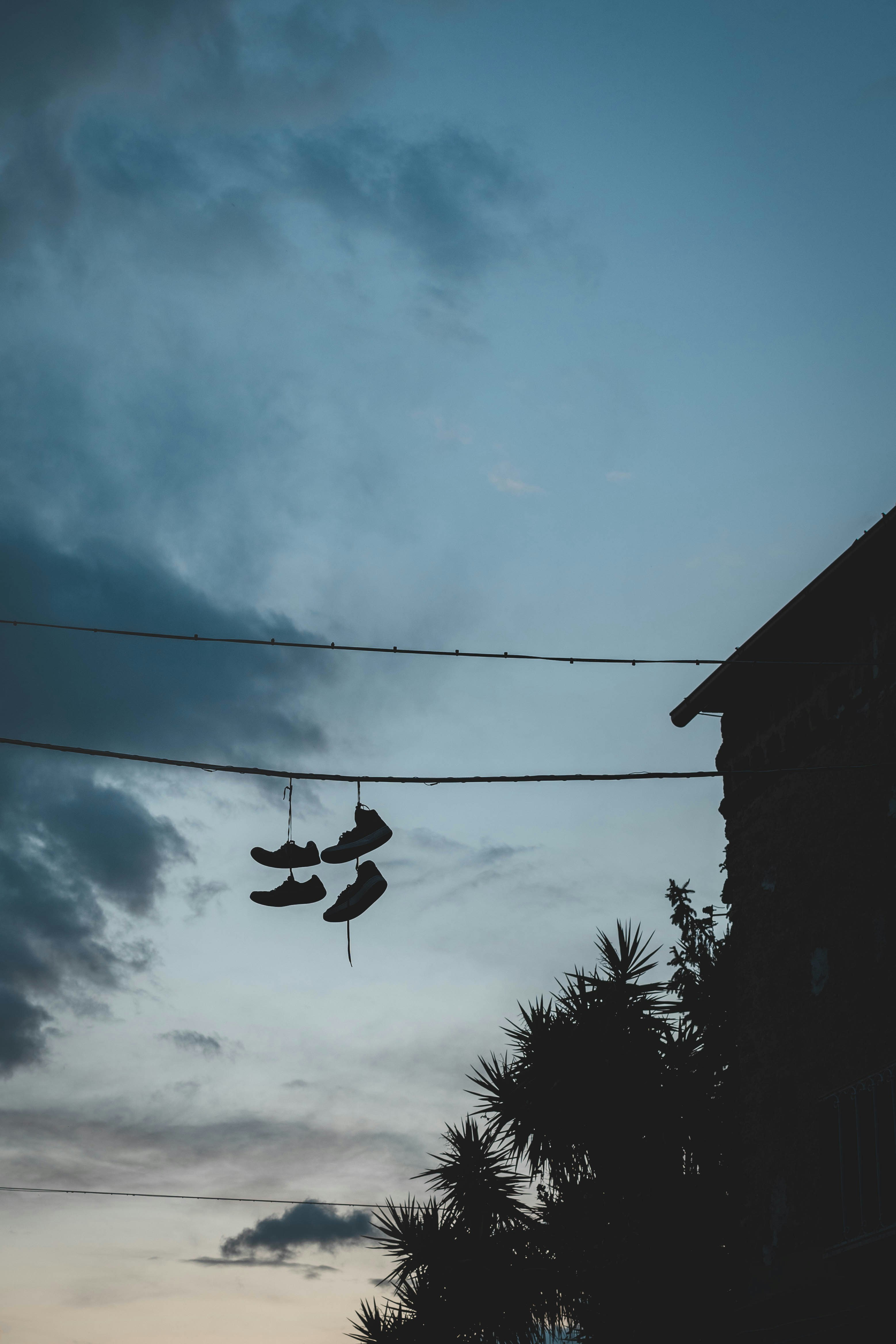 Shoes on a Wire Against a Dusk Sky Over a Quiet Street