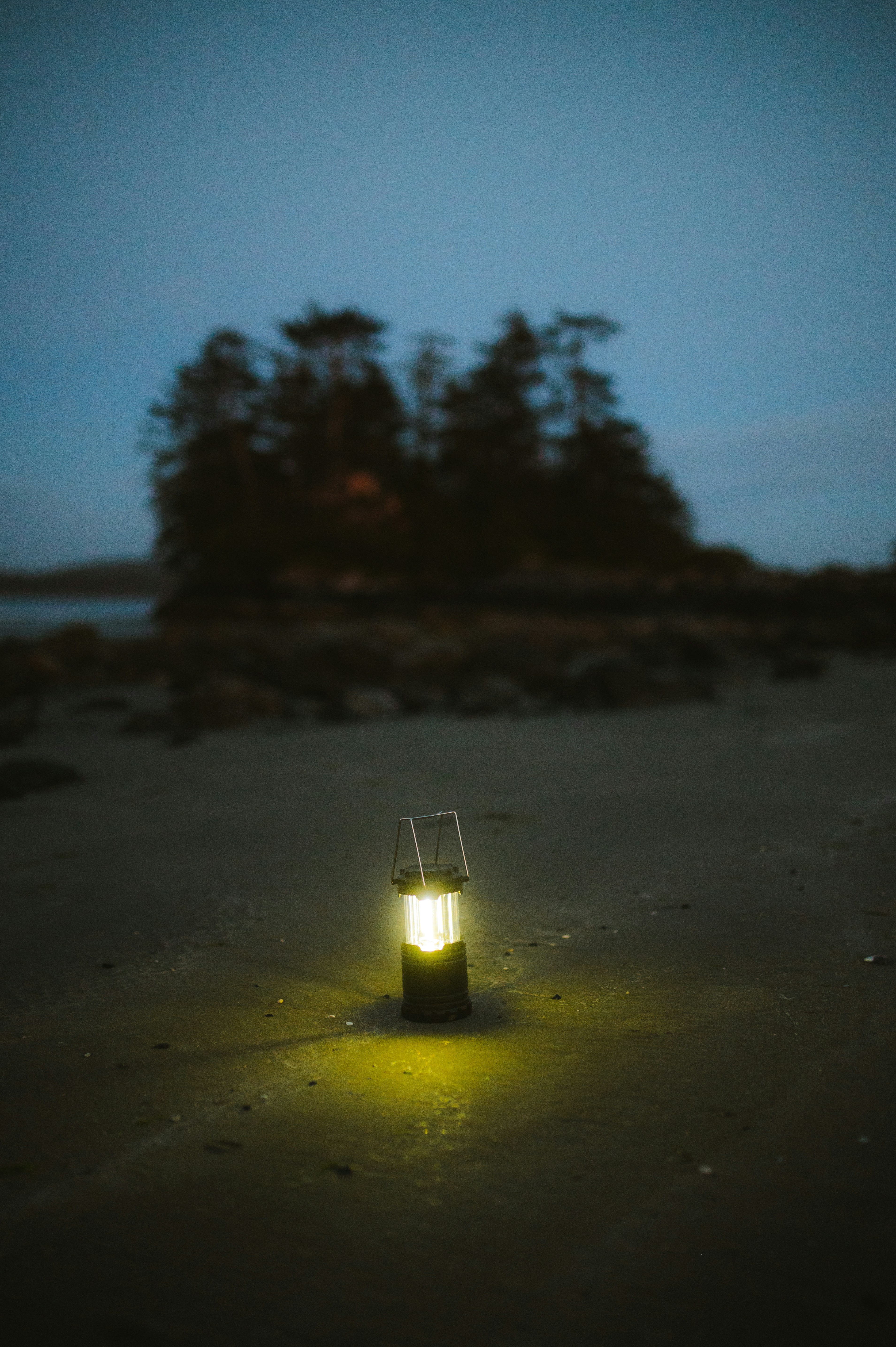 Glow on the Wet Sand: a lone lantern anchors the blue-hour shoreline