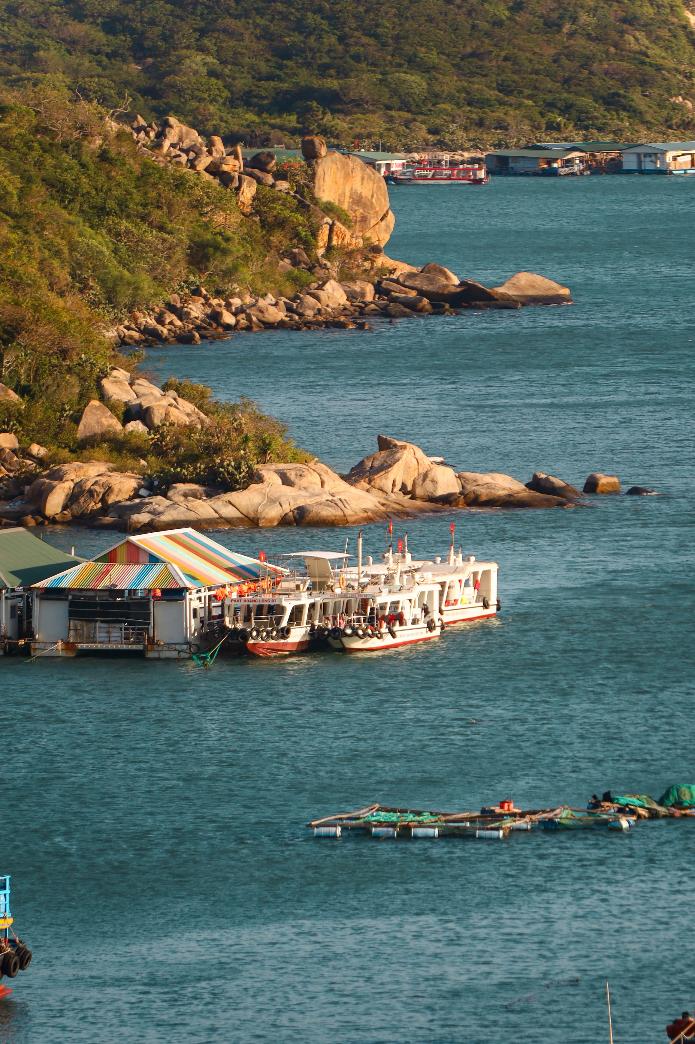 Striped Canopy Dock: Boats Moored by a Rocky Coastal Inlet