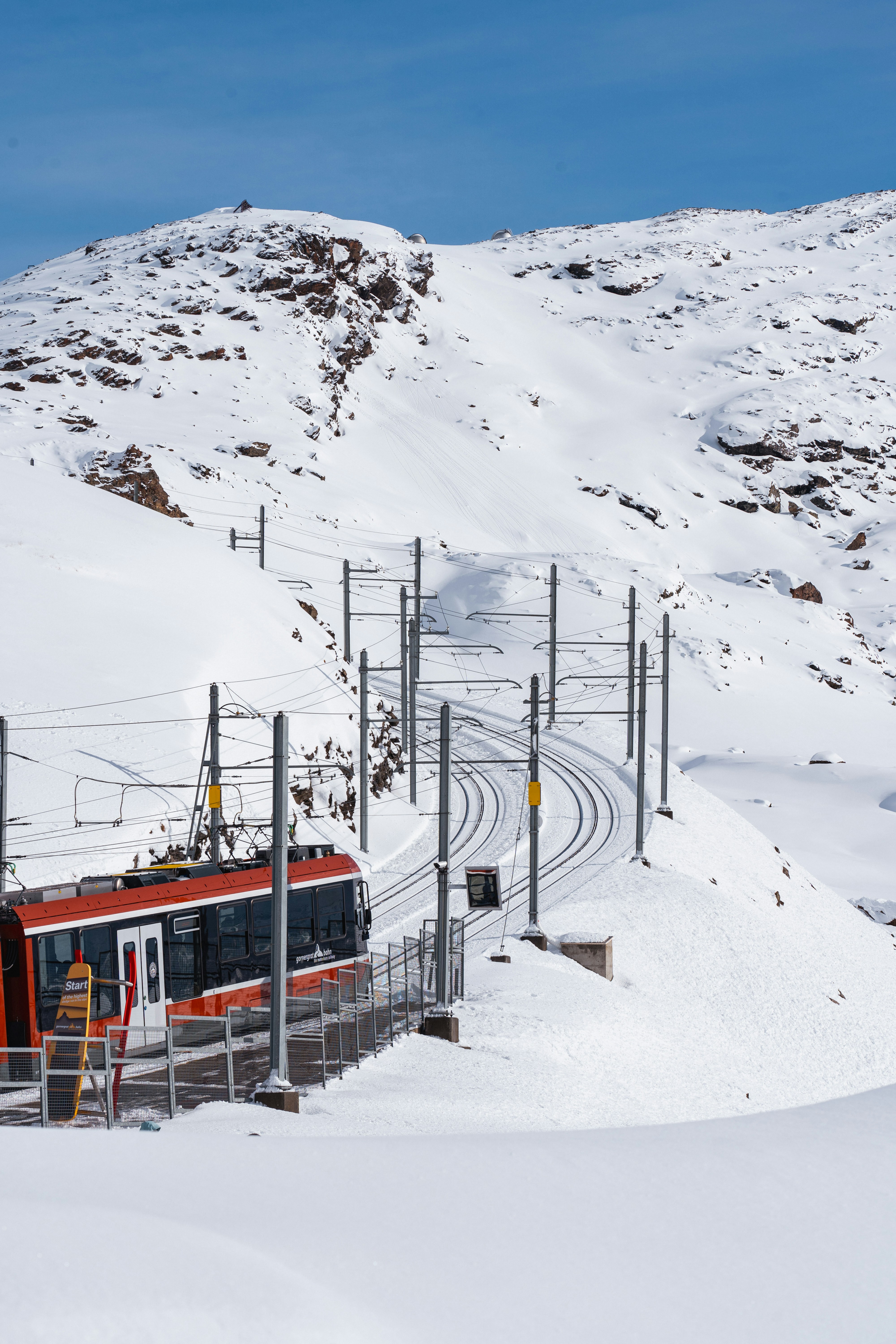 Snowbound Rails: A Red Locomotive Wends Through Winter Chaparral