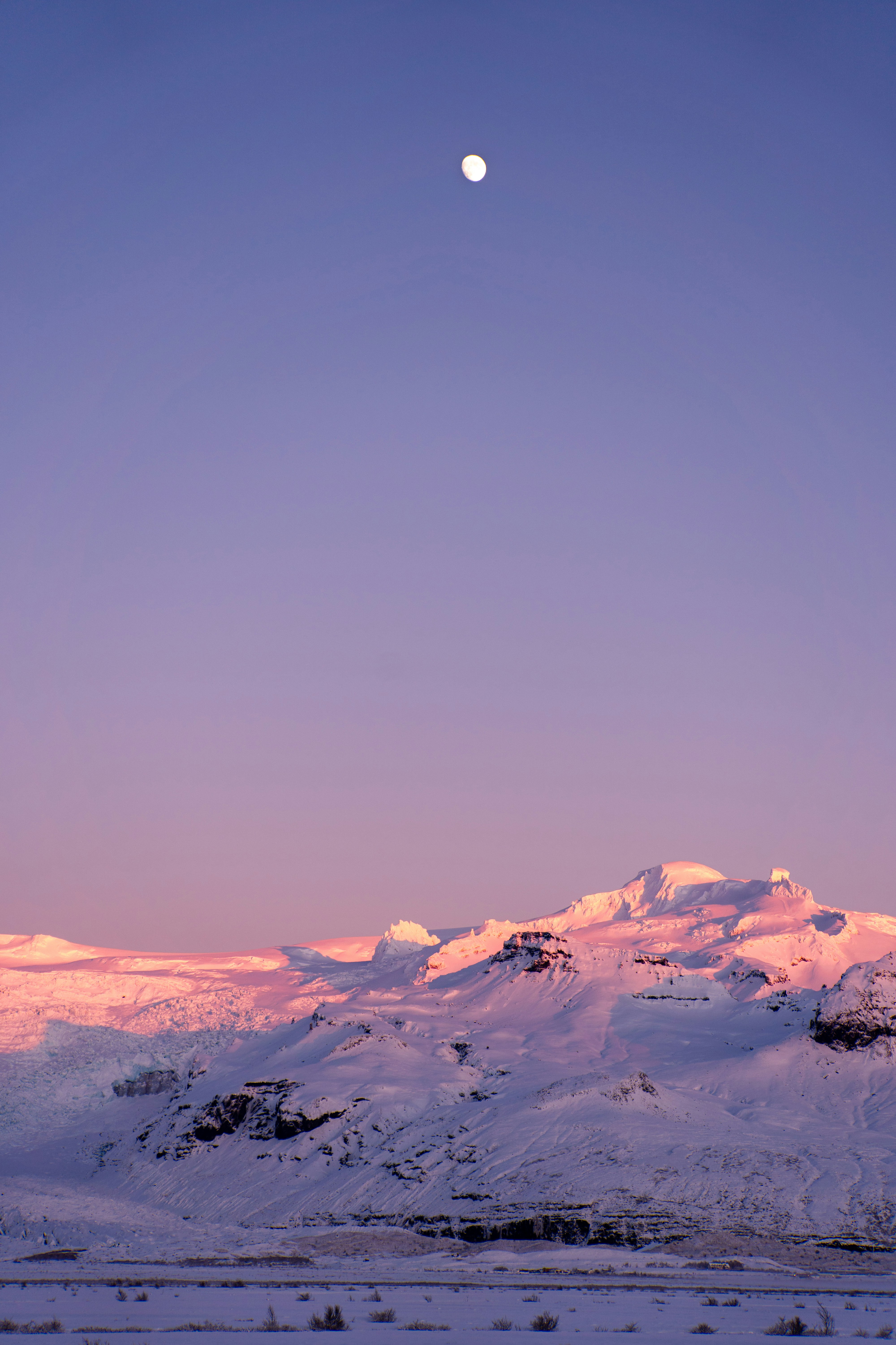 The moon is setting over a snowy mountain range photo – Free Iceland ...