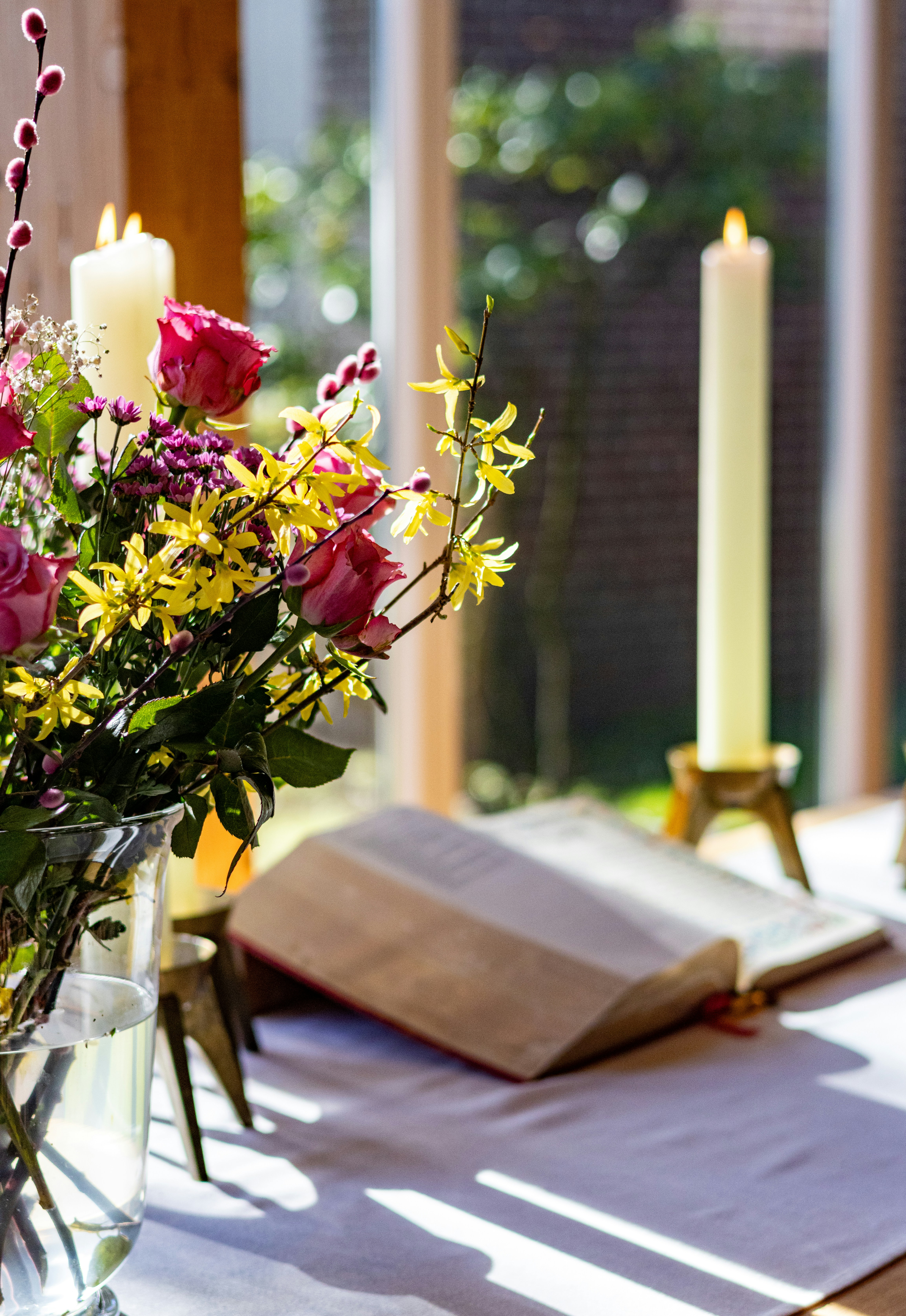 Sunlit Floral Still Life: Bouquet, Book, and Candlelight