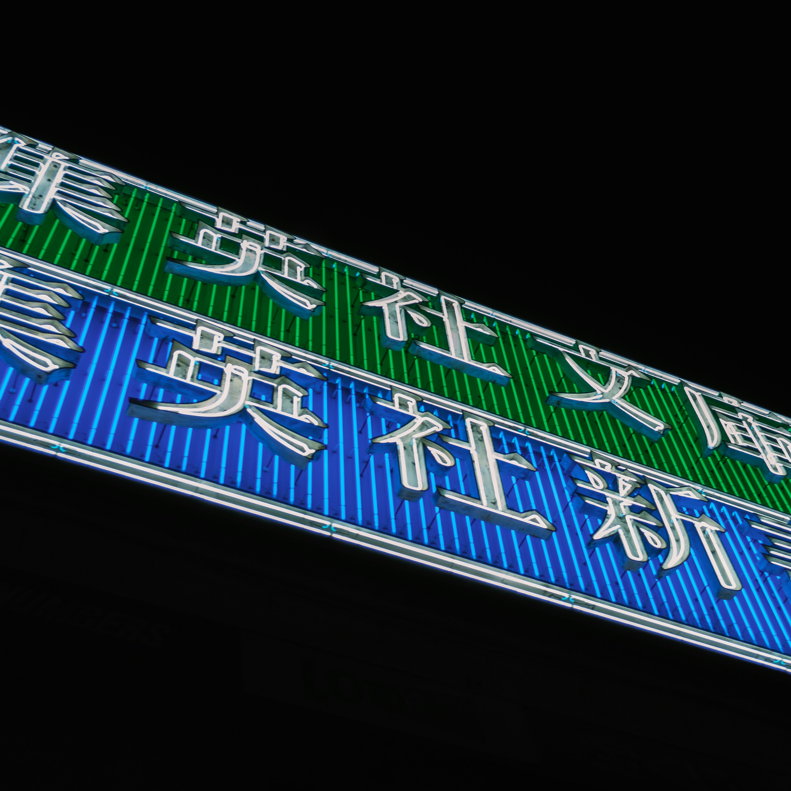 Diagonal Neon Kanji Sign: Emerald Green and Electric Blue Under Nightfall