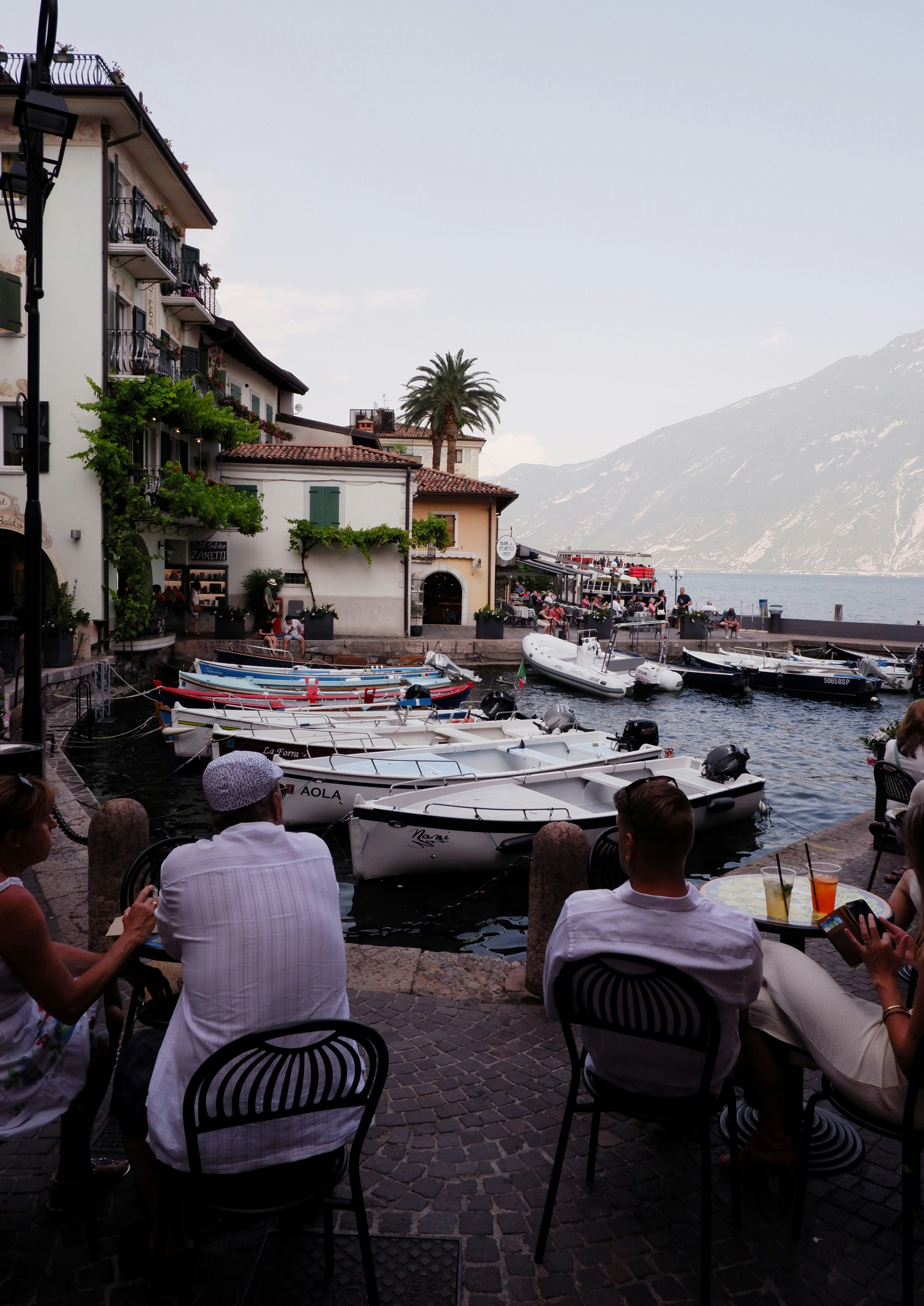 Quayside Reverie: Boats, Café Tables, and a Mountain Backdrop