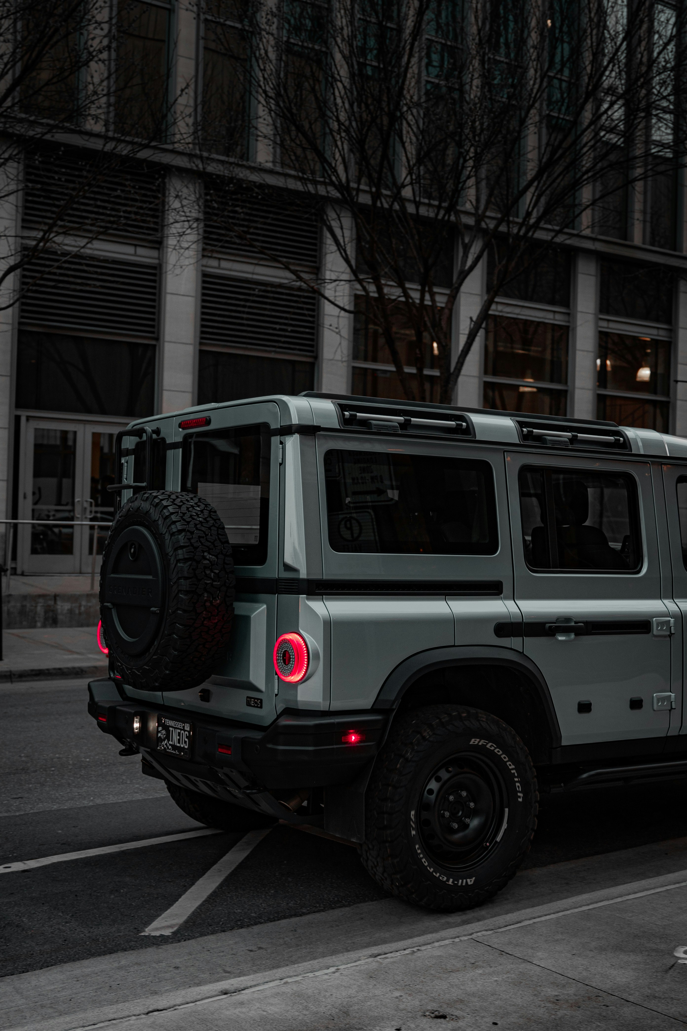 Neon Halo on the Defender: Night Parking in a Quiet Downtown