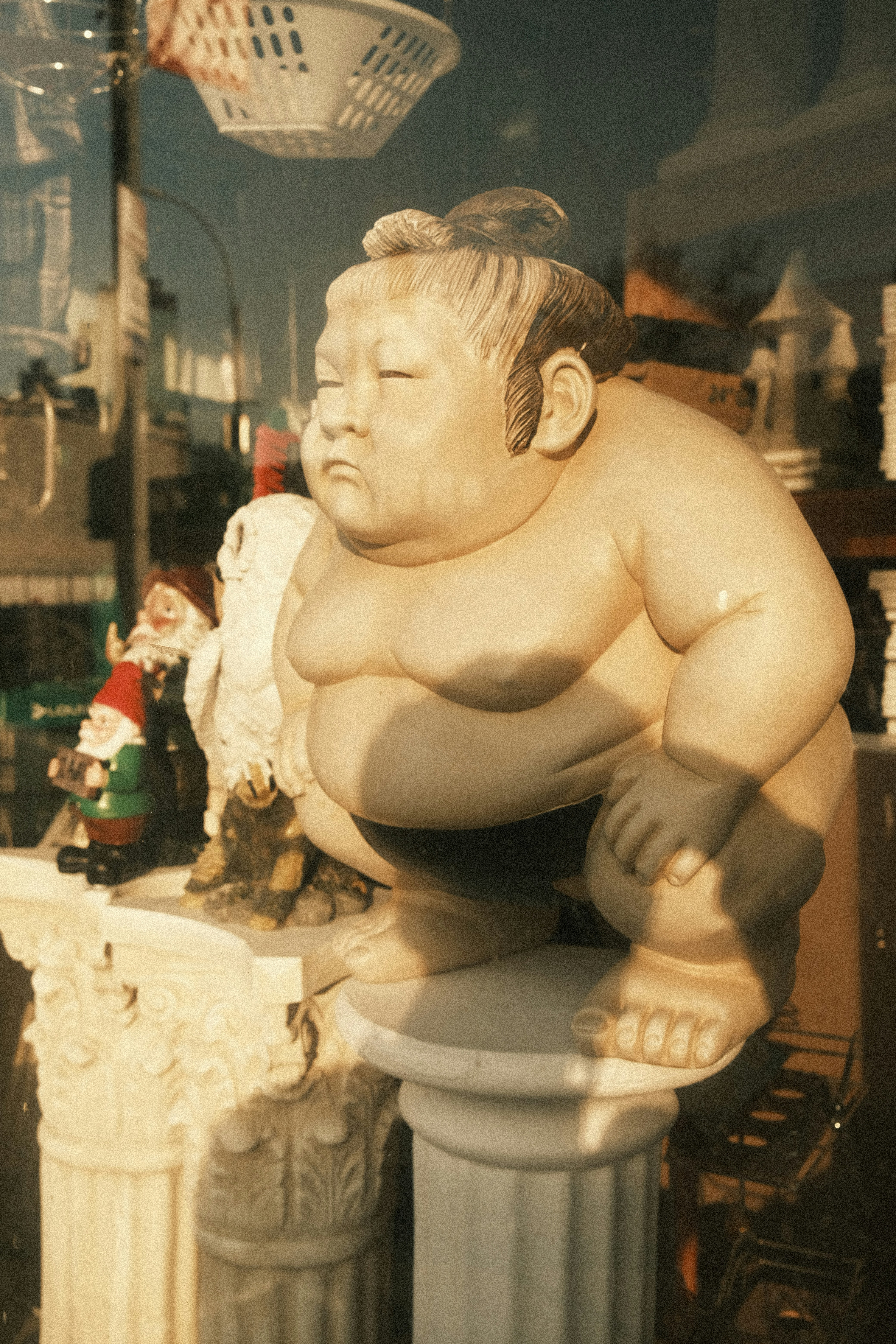 A statue of a sumo wrestler sitting on a pedestal photo – Free Portrait ...